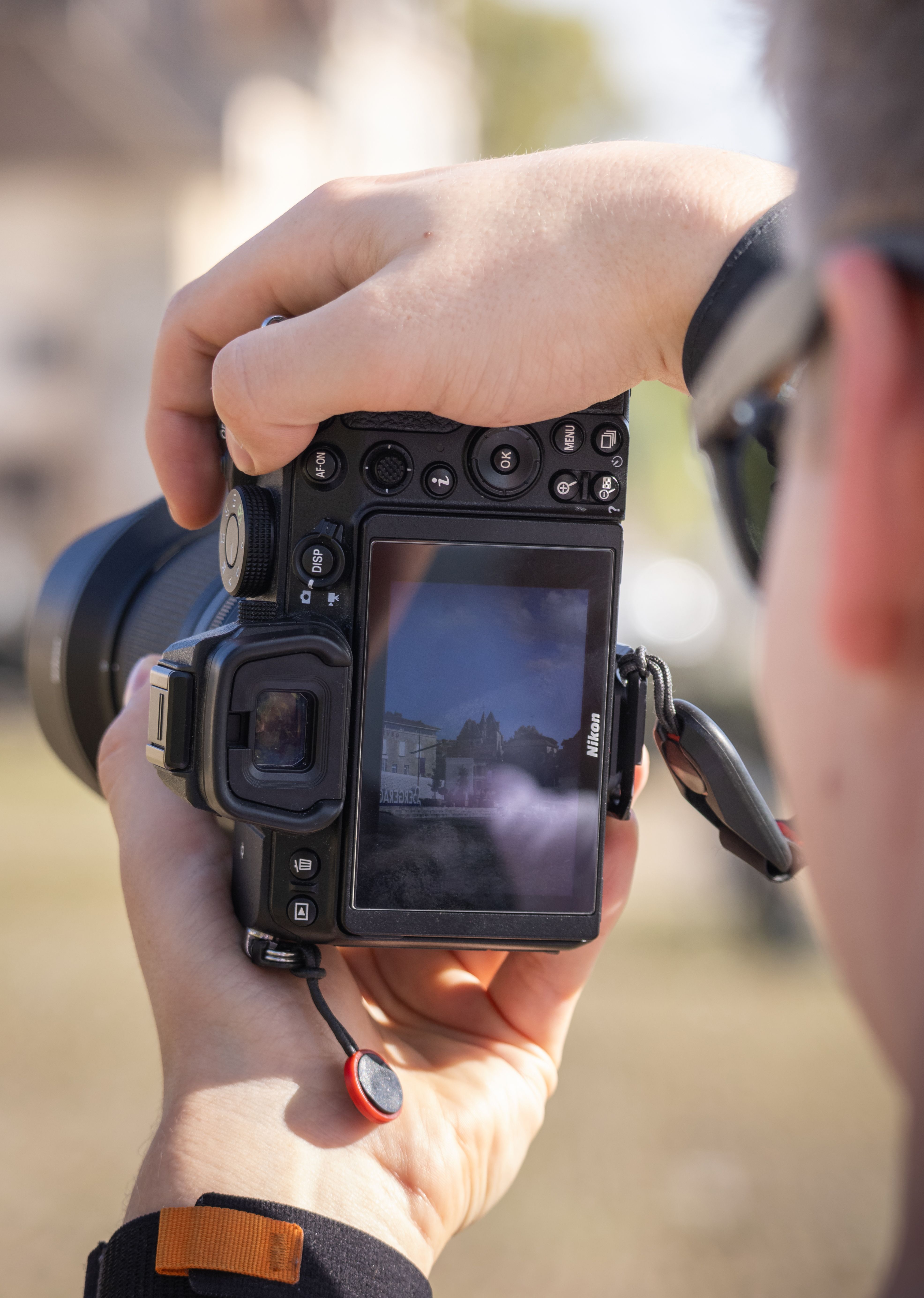 Close-up of a Photographer Capturing an Outdoor Scene · Free Stock Photo