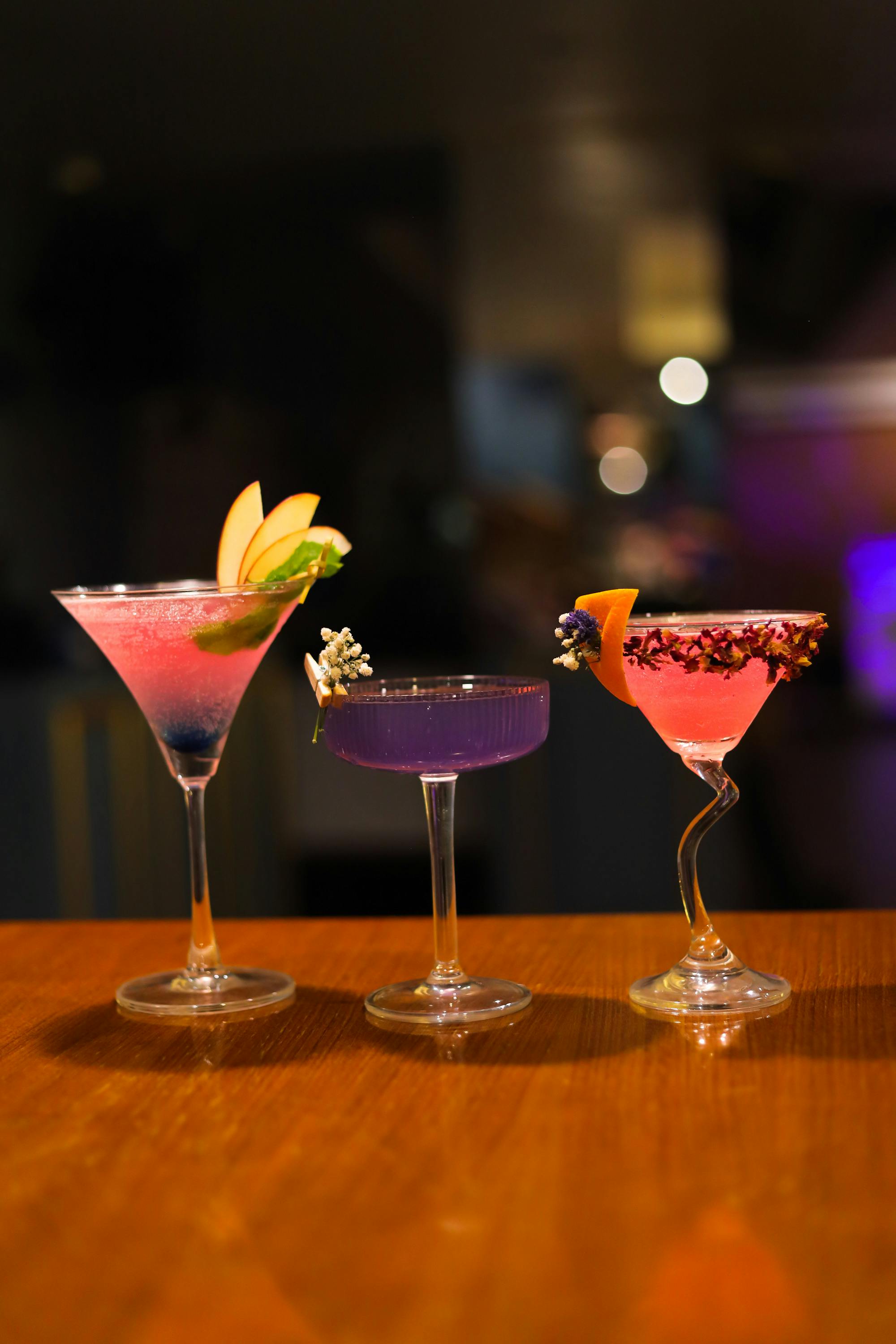 Vibrant Cocktails on Elegant Wooden Table · Free Stock Photo