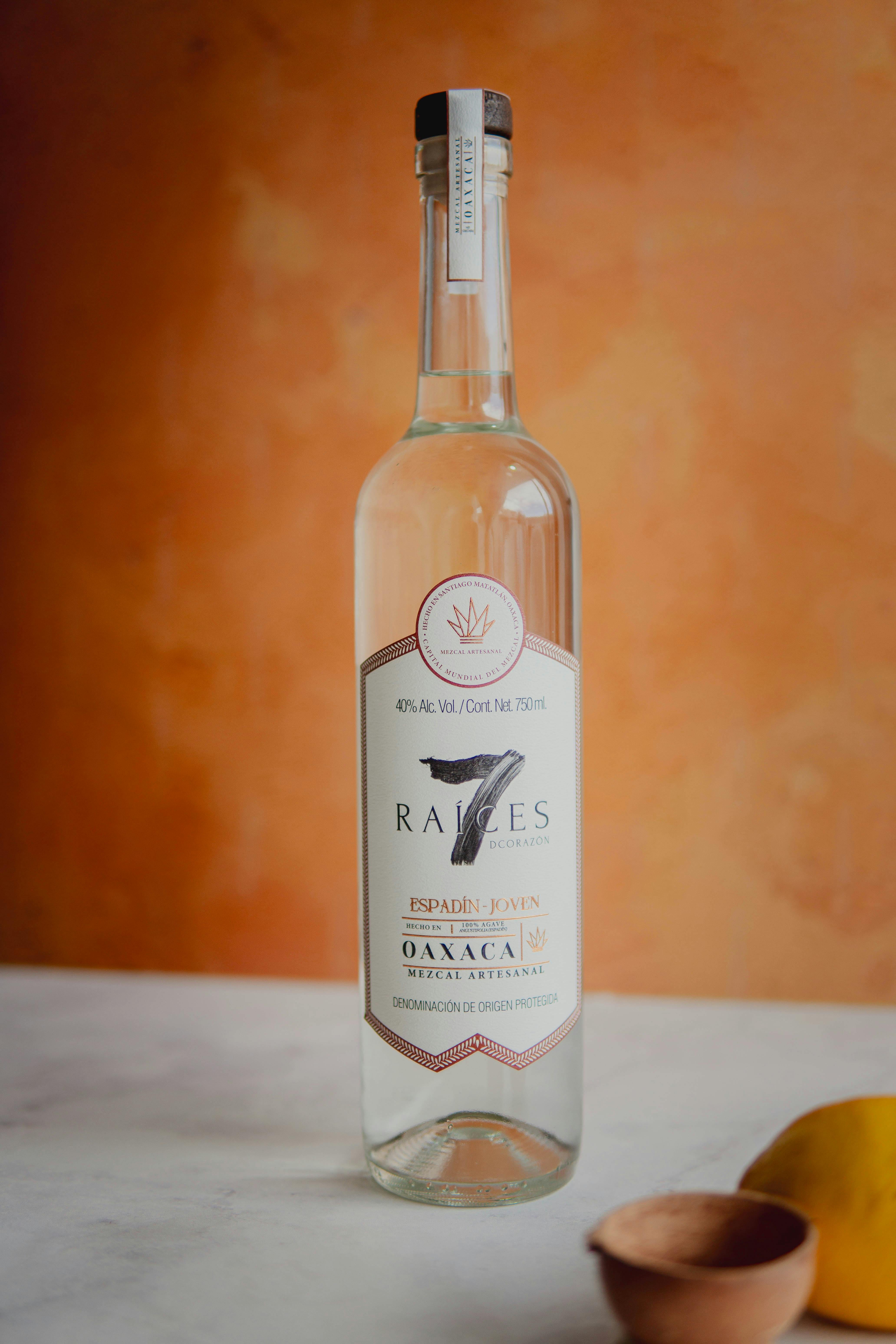 Artisanal Mezcal Bottle with Orange Background · Free Stock Photo