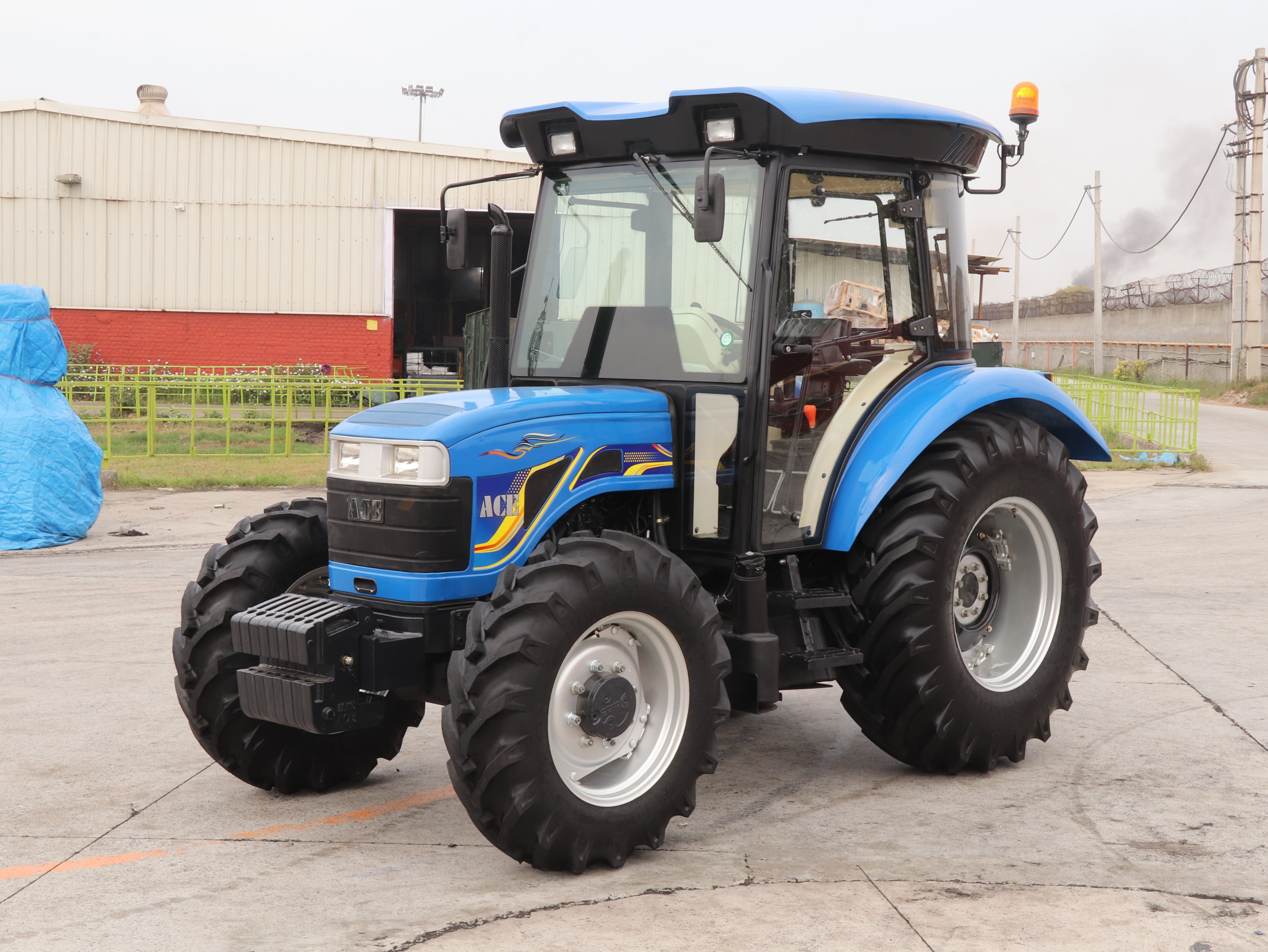 Modern Blue 4WD Tractor in Industrial Setting · Free Stock Photo