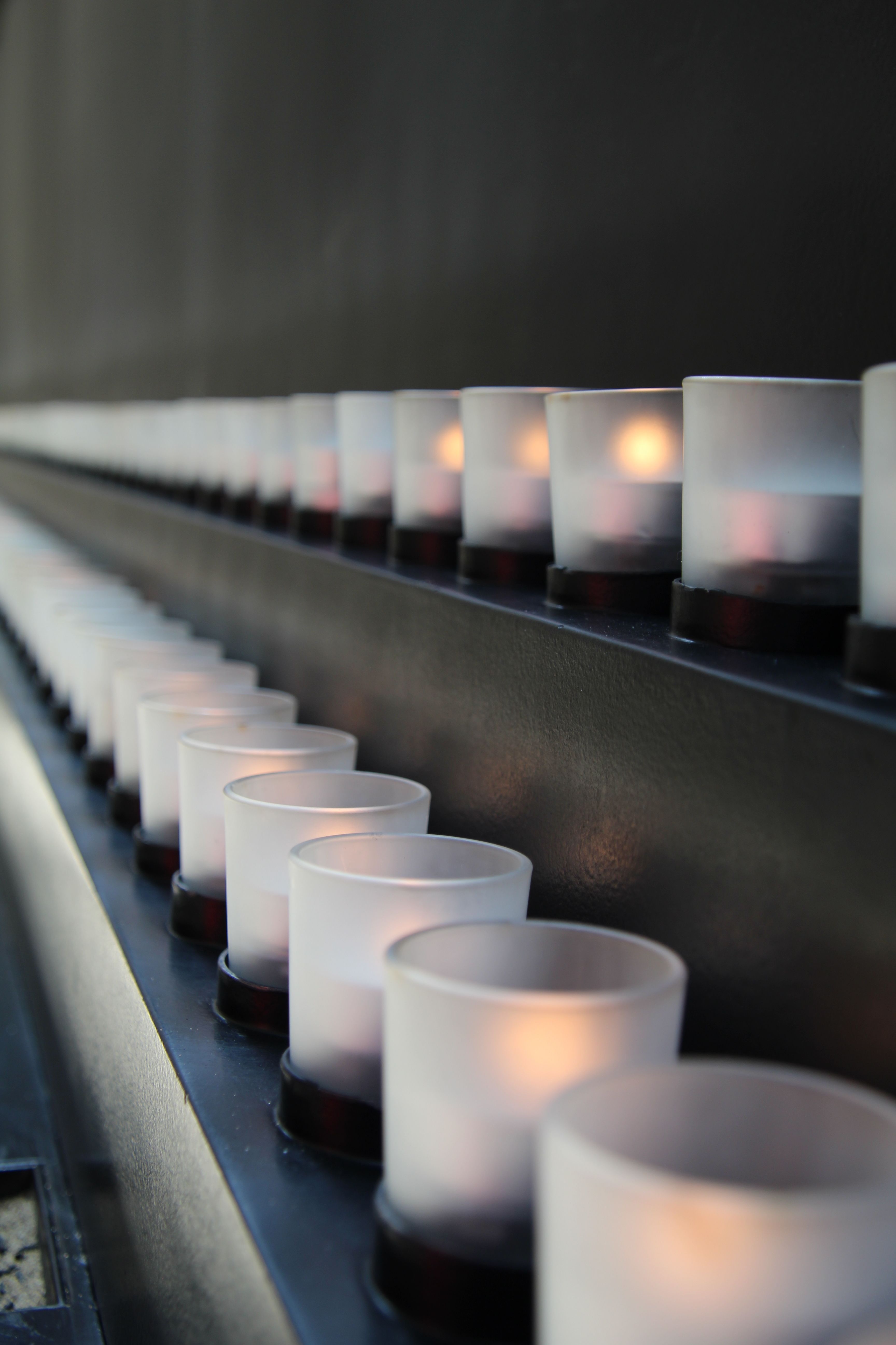 Row of Glowing Votive Candles in Dim Light · Free Stock Photo