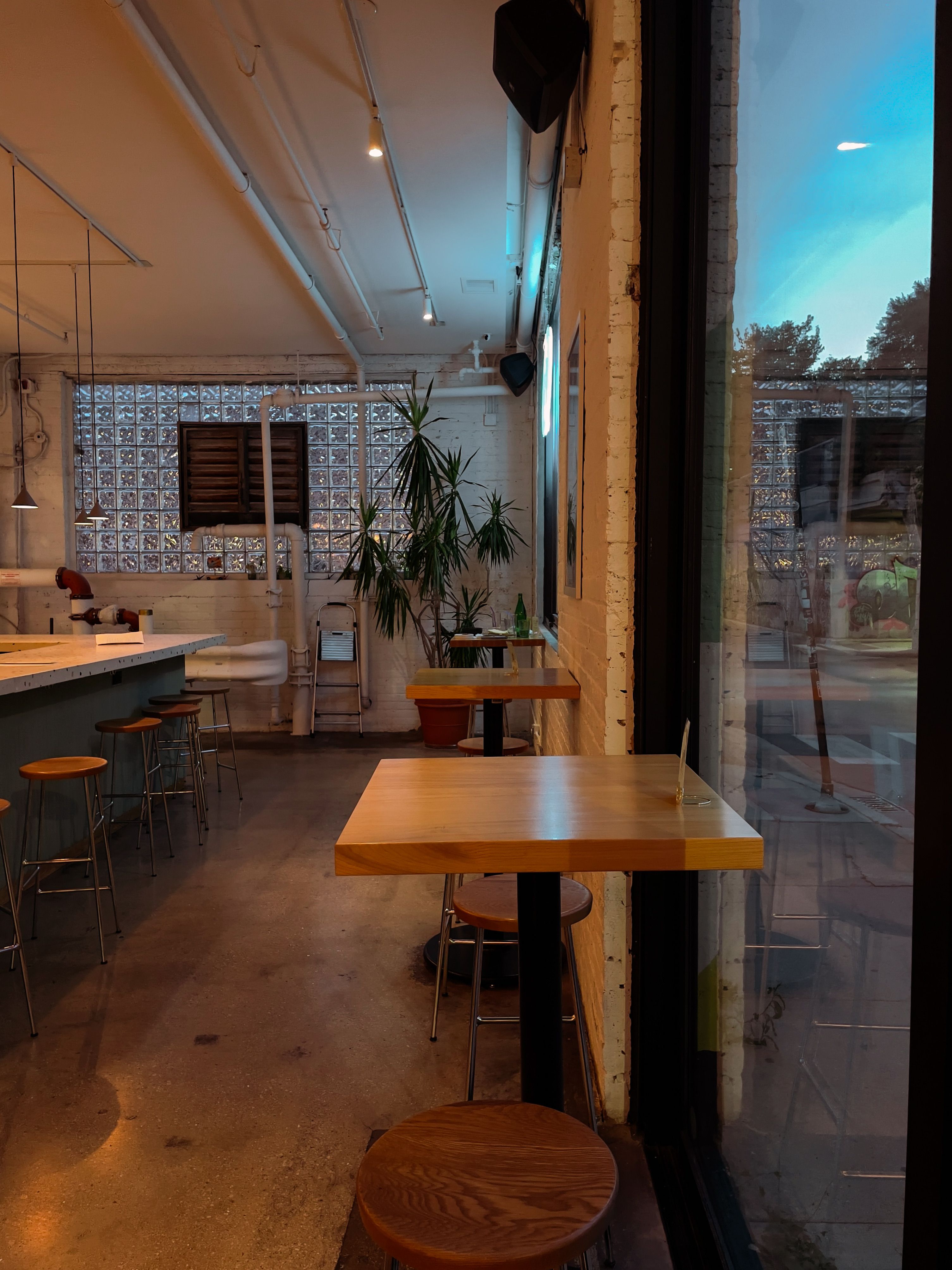 Cozy Cafe Interior with Large Windows and Indoor Plants · Free Stock Photo