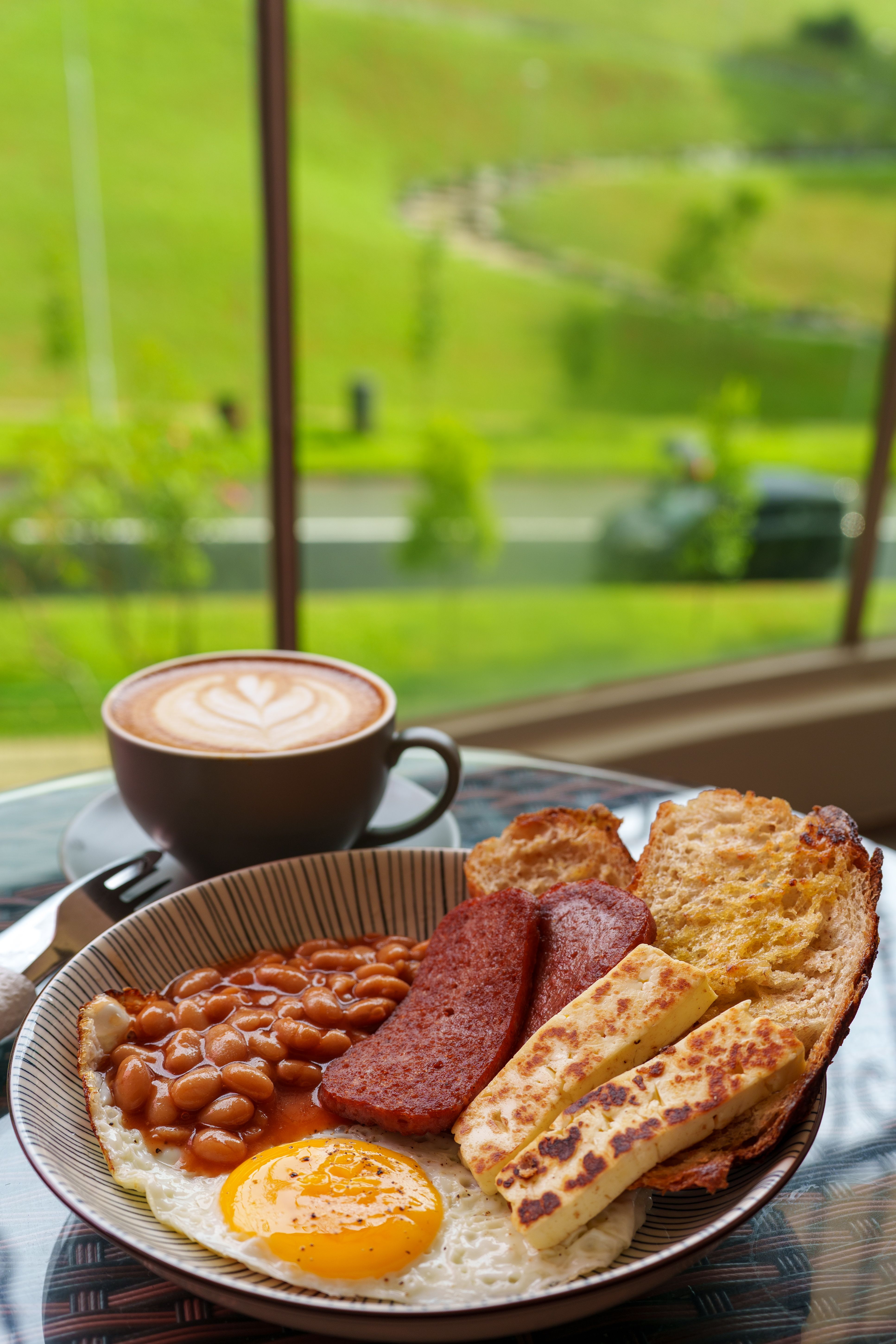 Hearty Breakfast with Cappuccino and Scenic View · Free Stock Photo