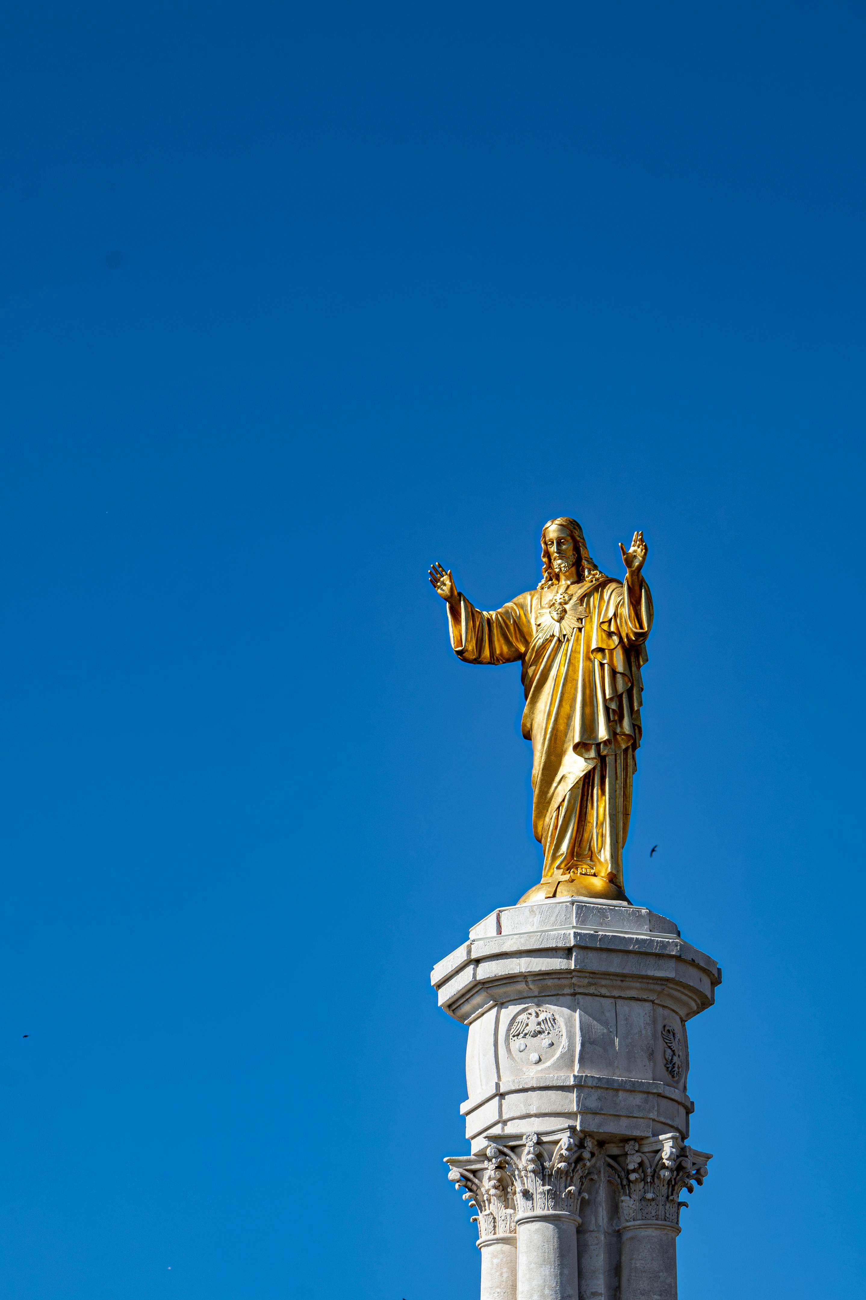 Golden Christ Statue Against Clear Blue Sky · Free Stock Photo