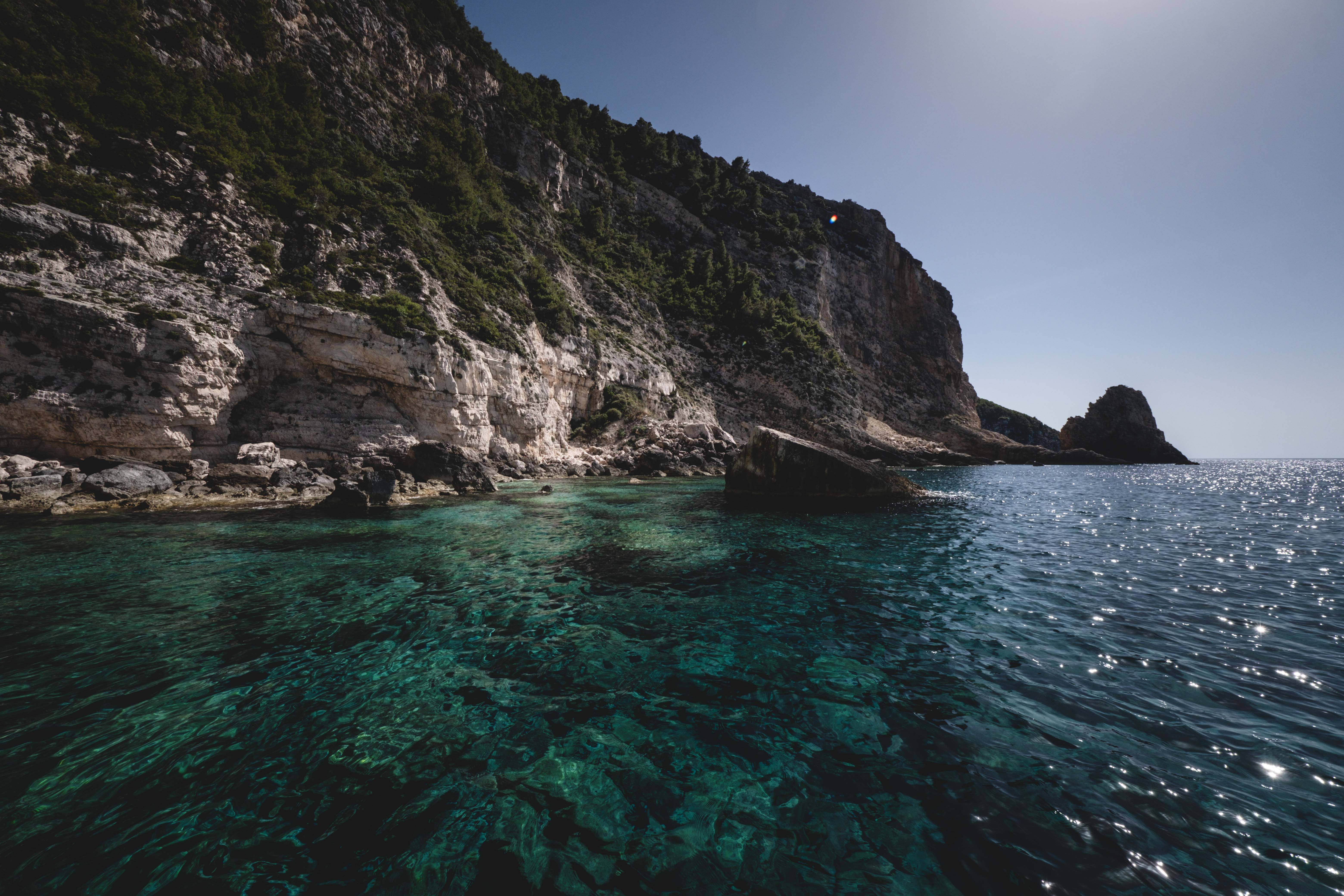 Dramatic Rocky Coastal Cliff and Turquoise Sea · Free Stock Photo