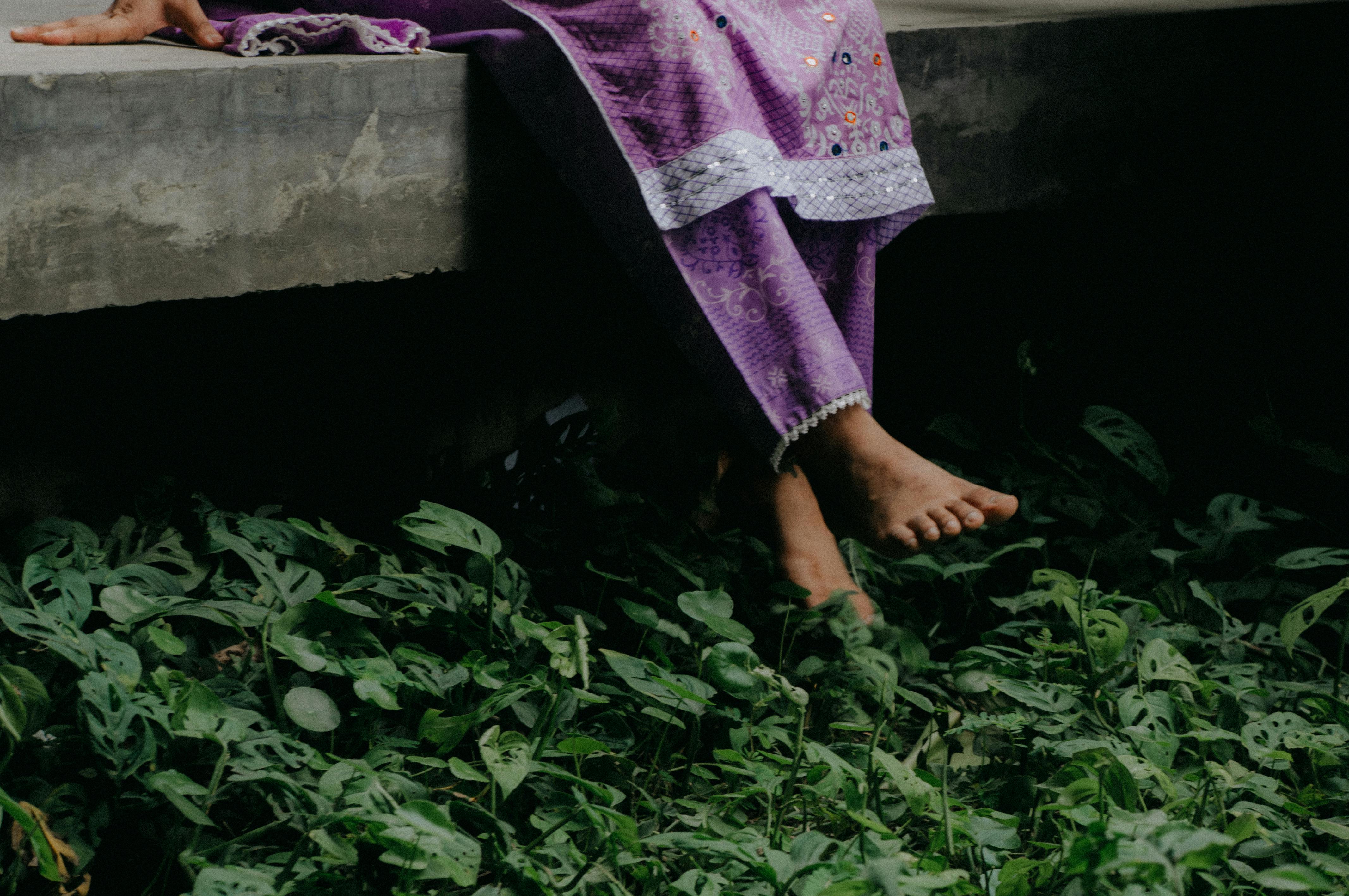 Woman's Feet Dangling Over Garden Ledge · Free Stock Photo
