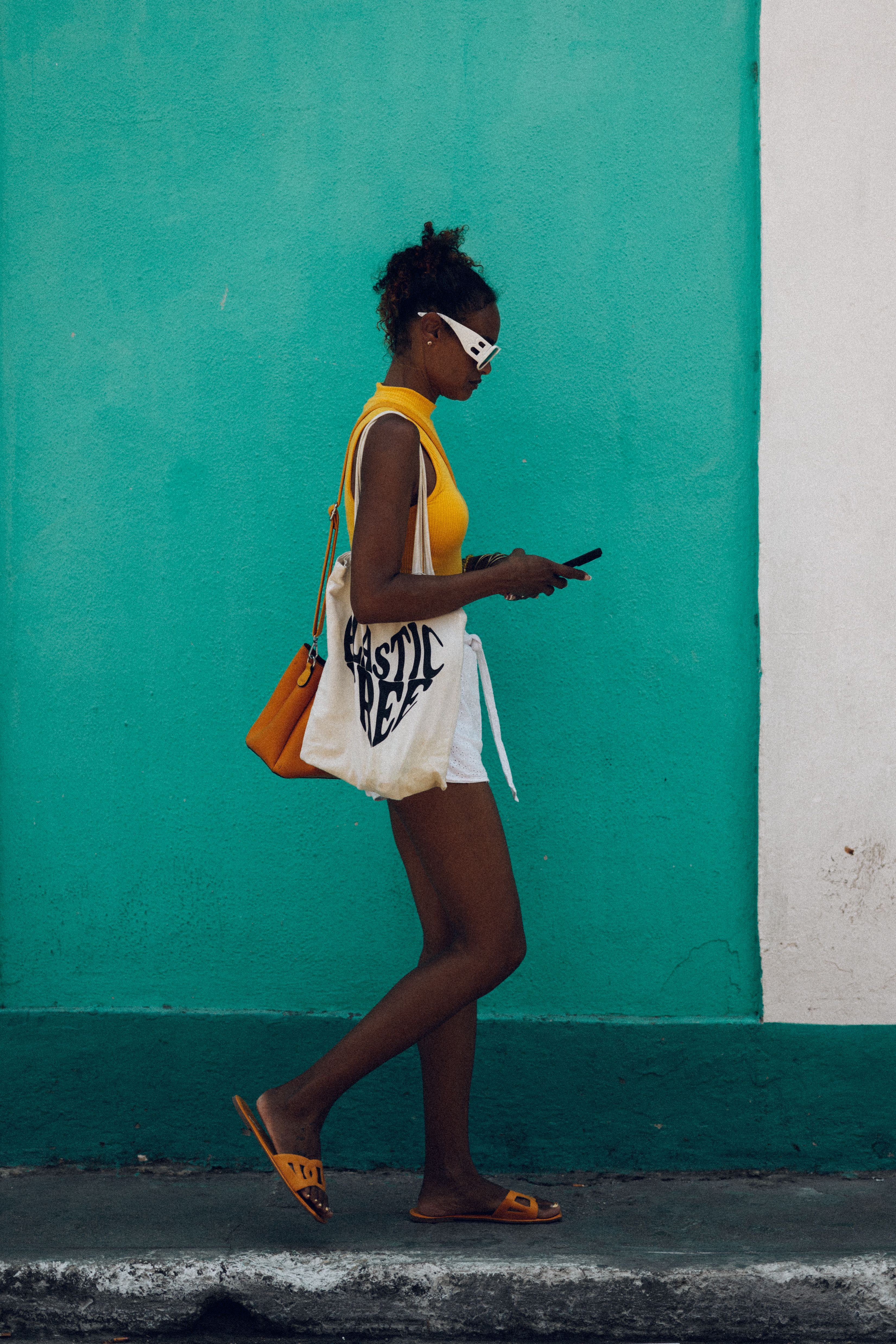 Young Woman Walking by Vibrant Teal Wall in Cuba · Free Stock Photo