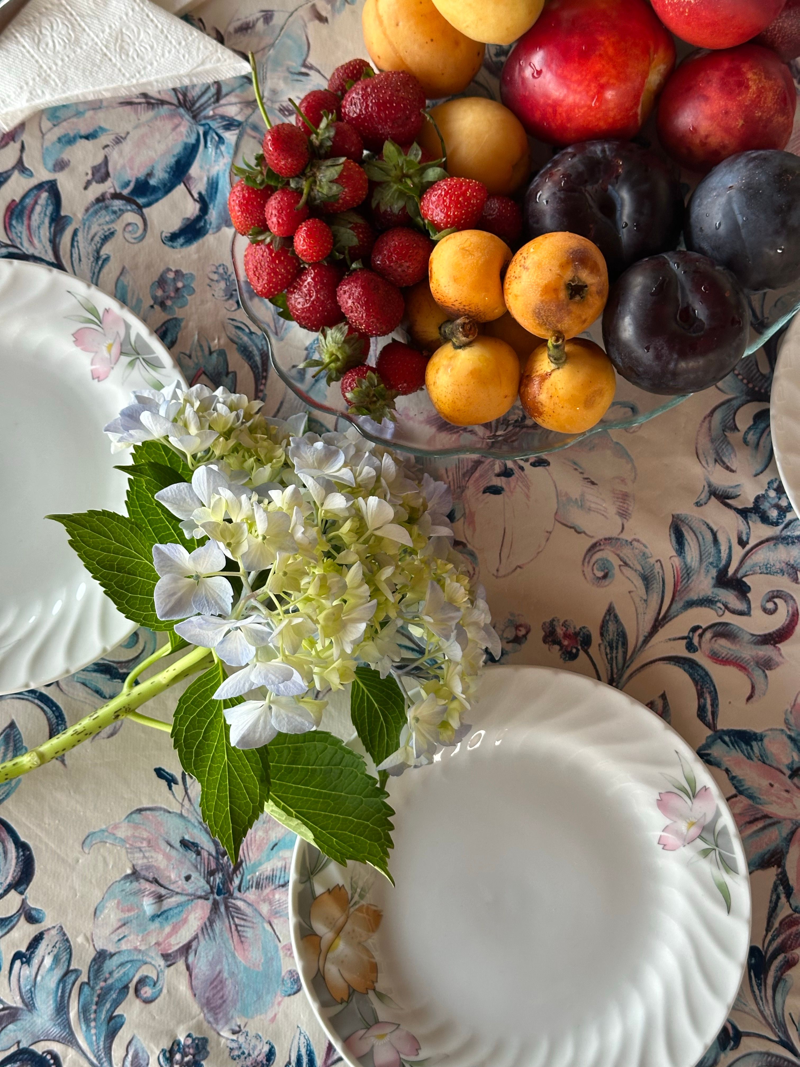 Colorful Fruit and Hydrangea on Floral Tablecloth · Free Stock Photo