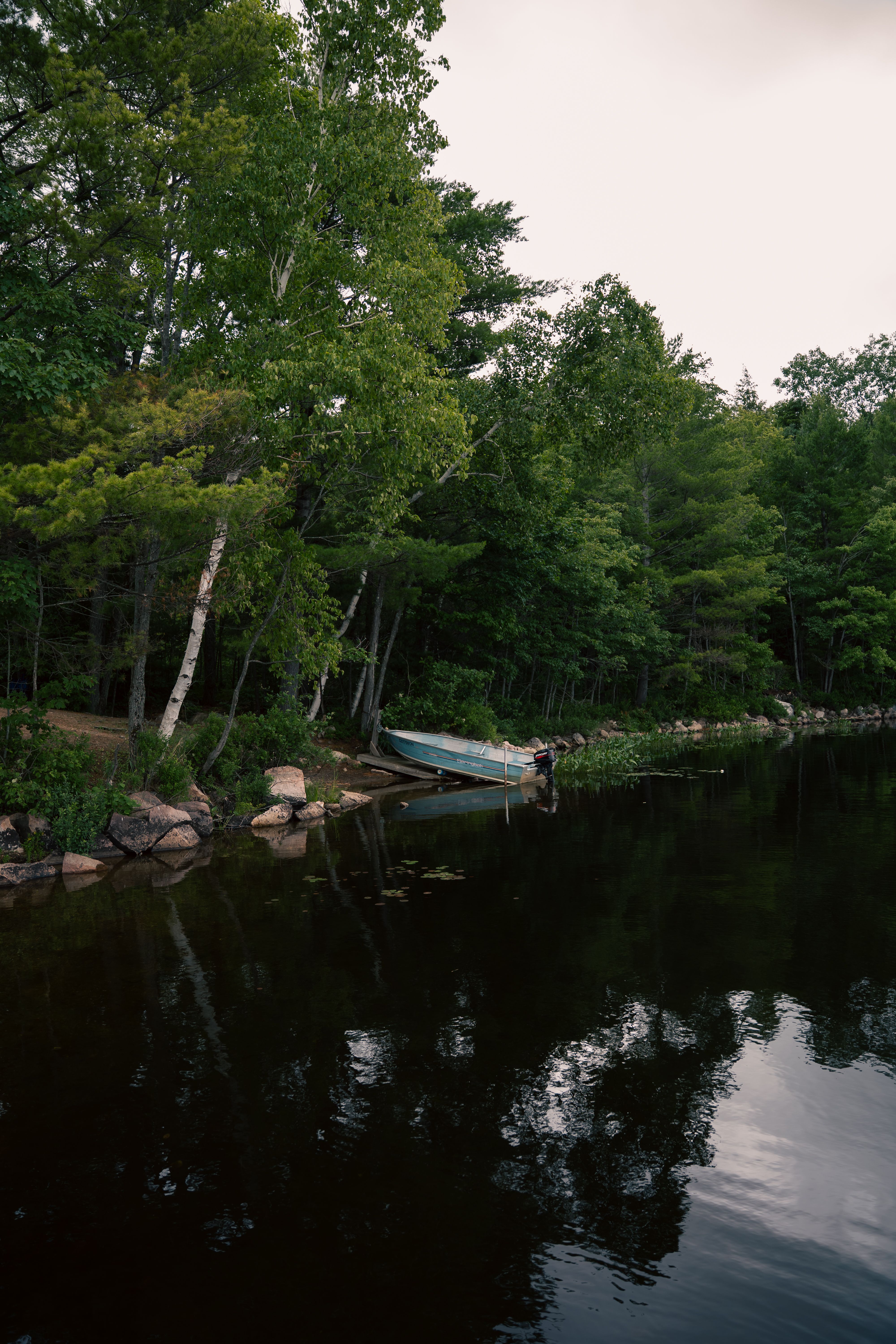 Serene Lakeside Scene with Wooden Boat · Free Stock Photo