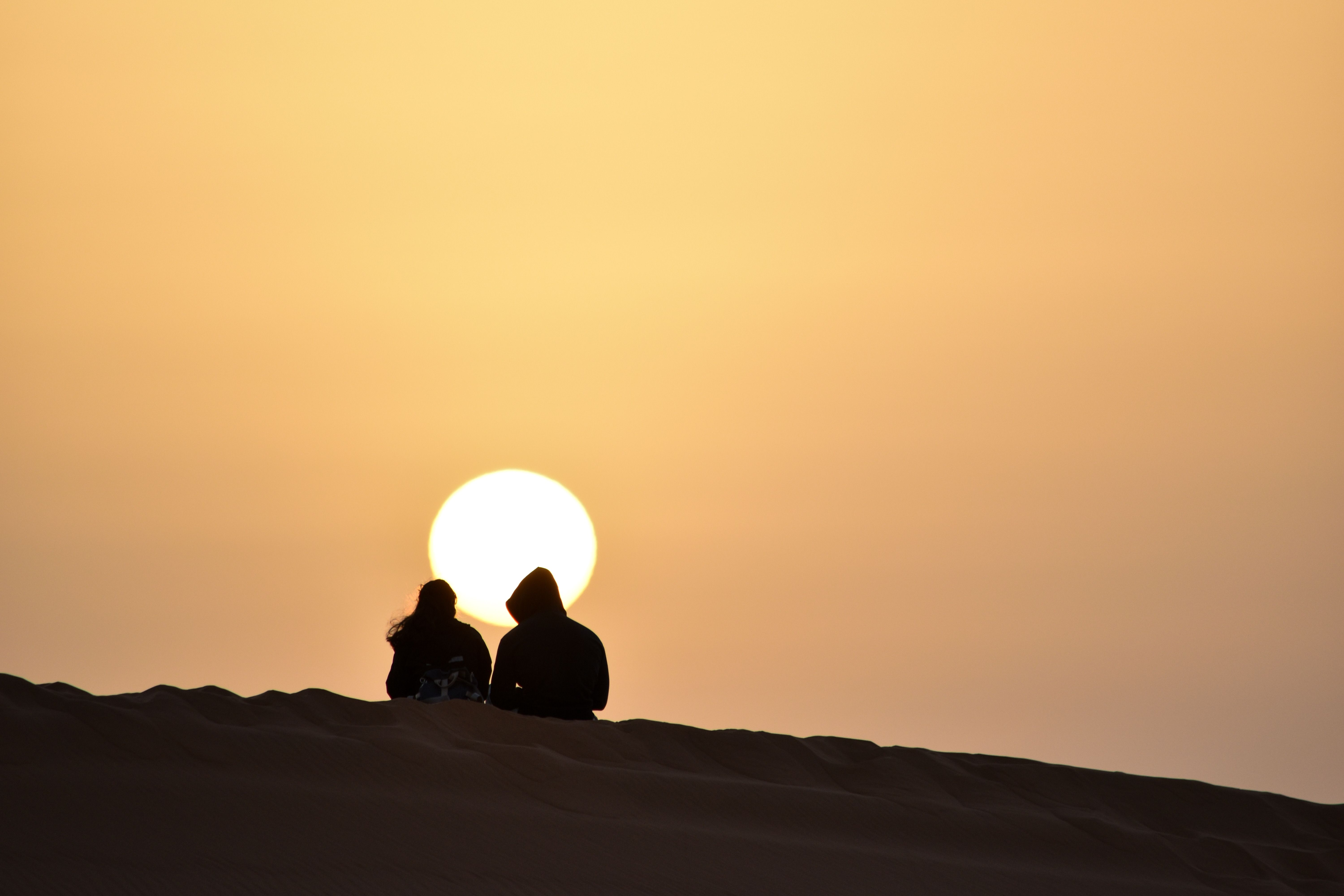 Peaceful Silhouette of Two at Sunset on a Desert · Free Stock Photo