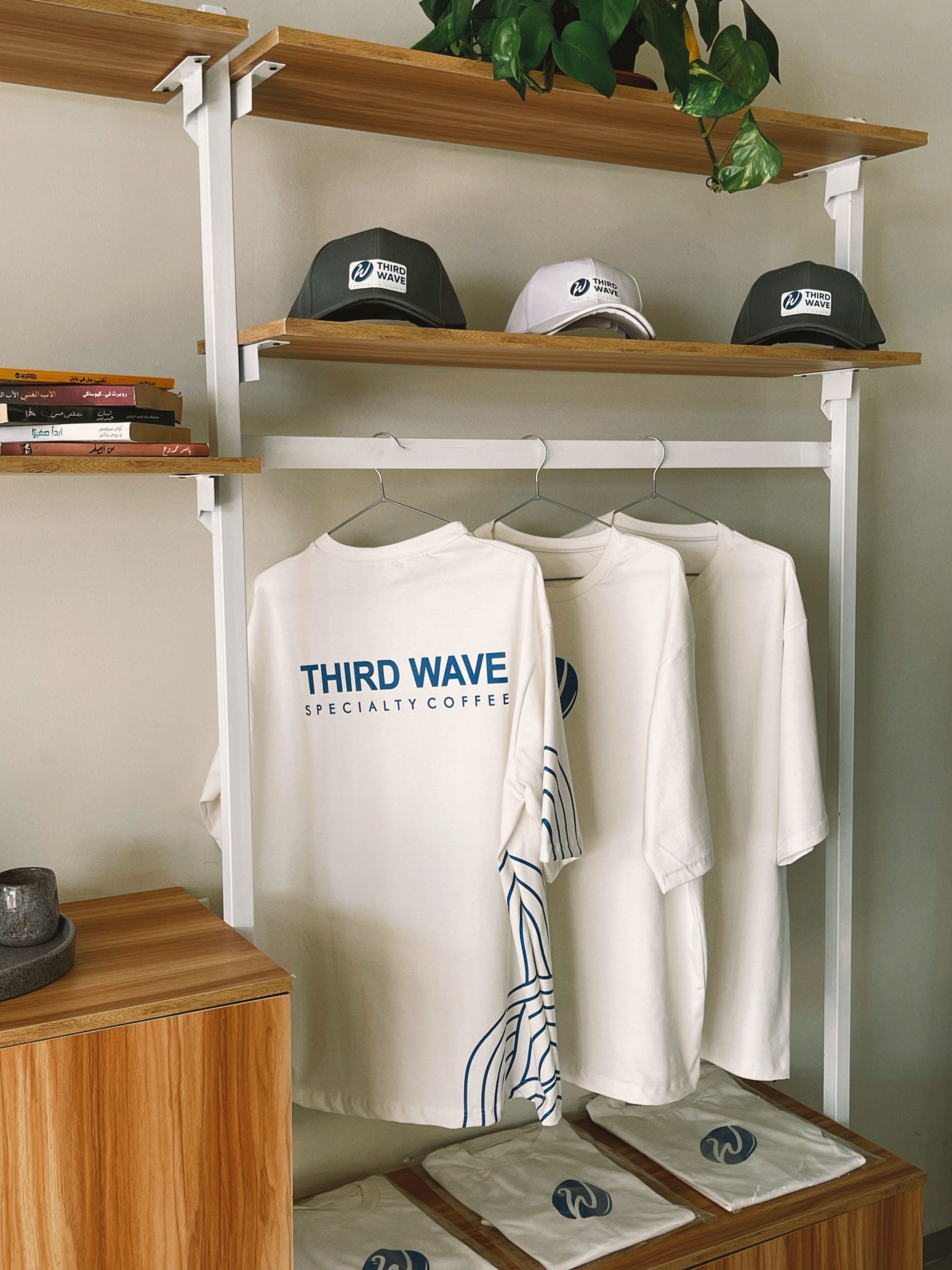 Cafe Merchandise Display with T-shirts and Caps · Free Stock Photo