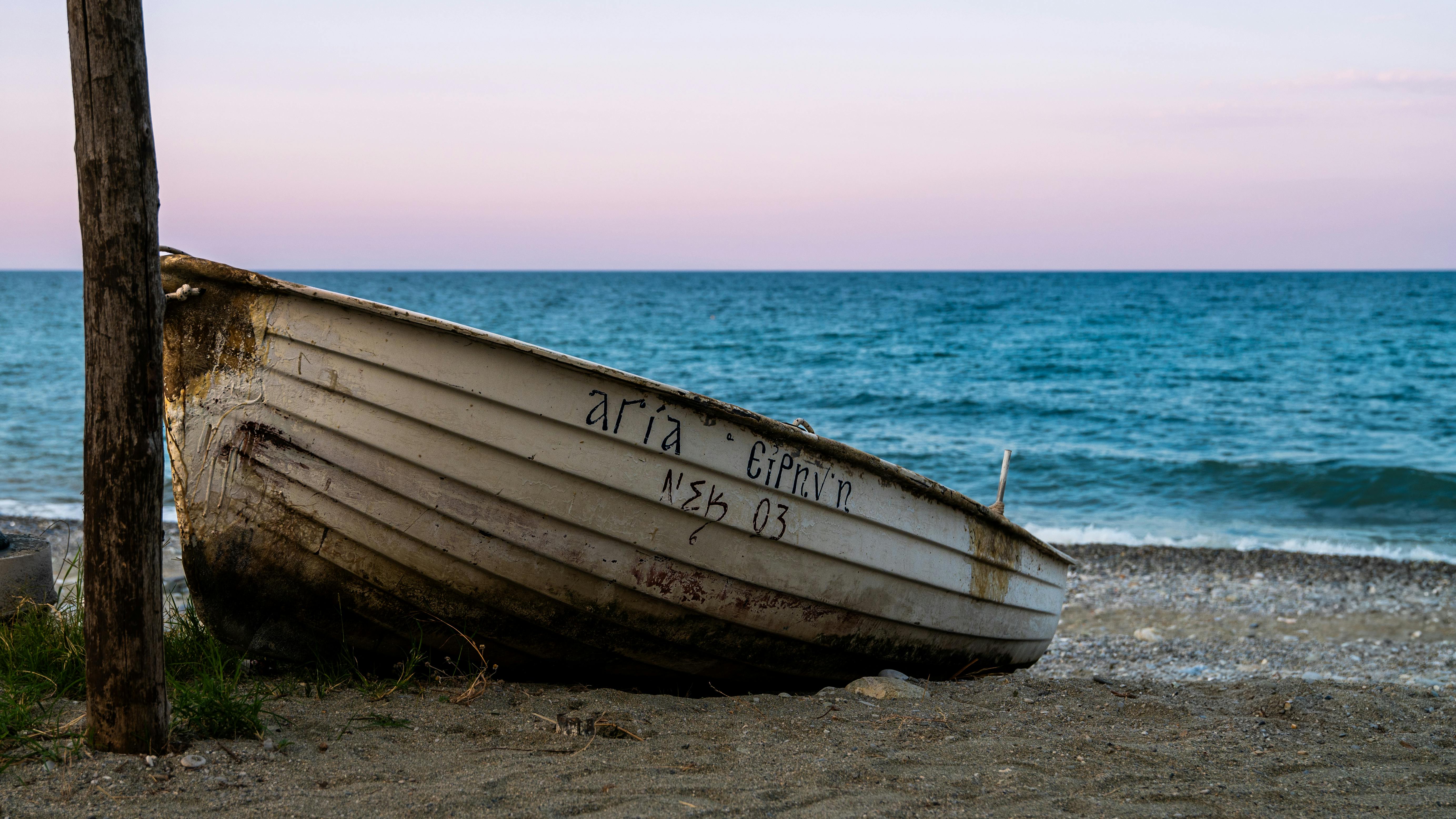 Barco Abandonado En La Tranquila Orilla Del Mar Al Atardecer · Foto de ...