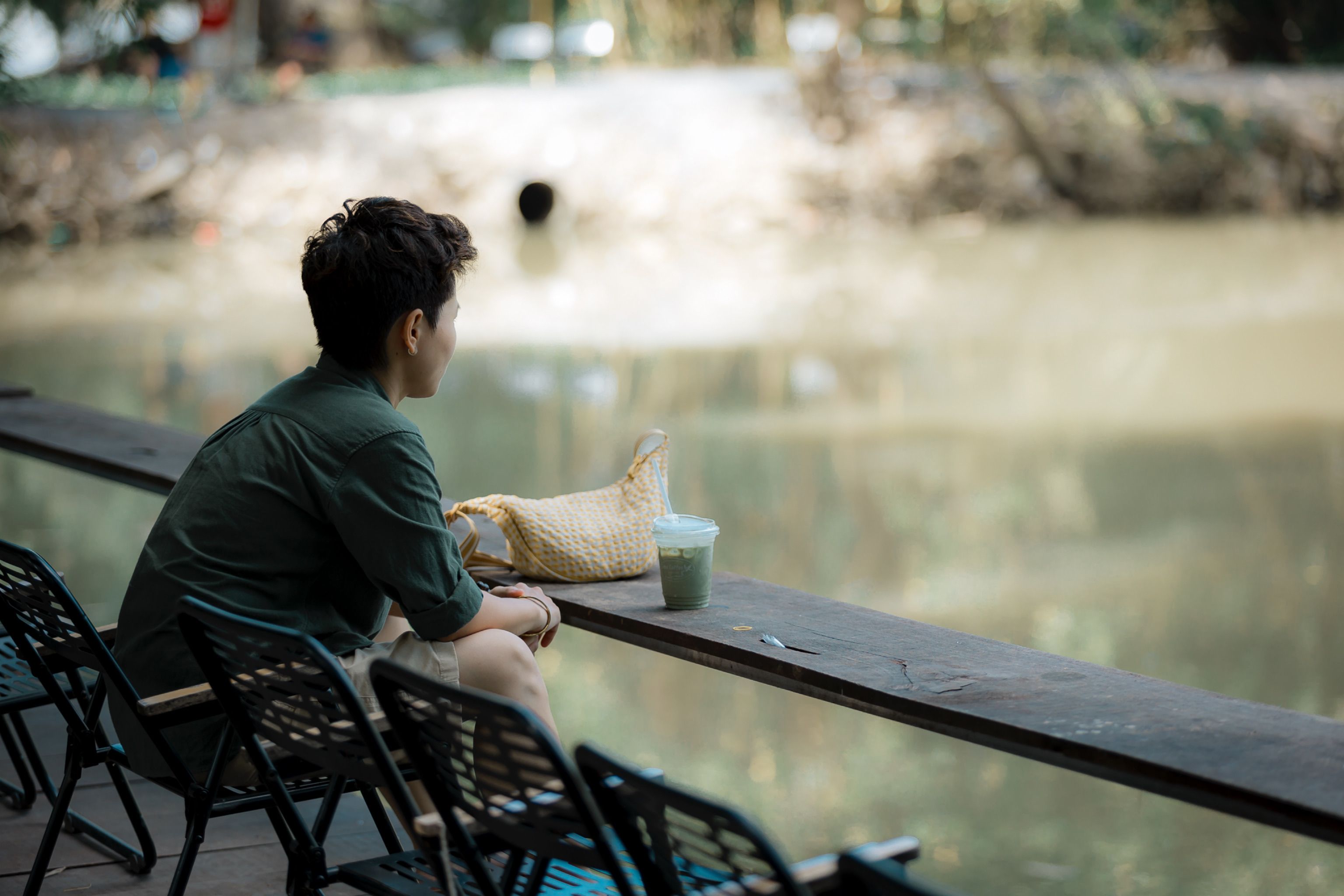Person Relaxing by Tranquil Riverside Outdoors · Free Stock Photo