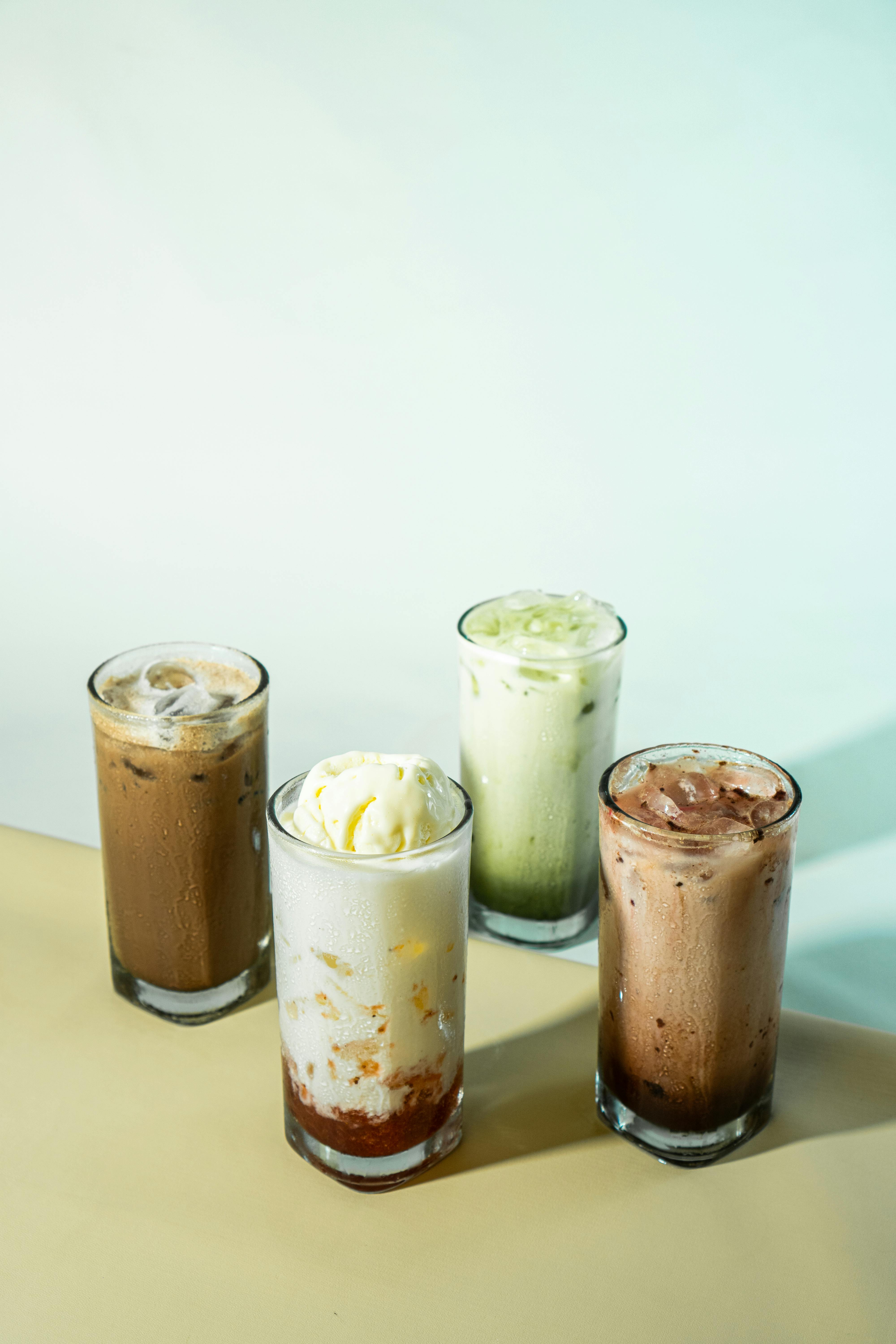 Refreshing Iced Beverages with Creamy Toppings · Free Stock Photo