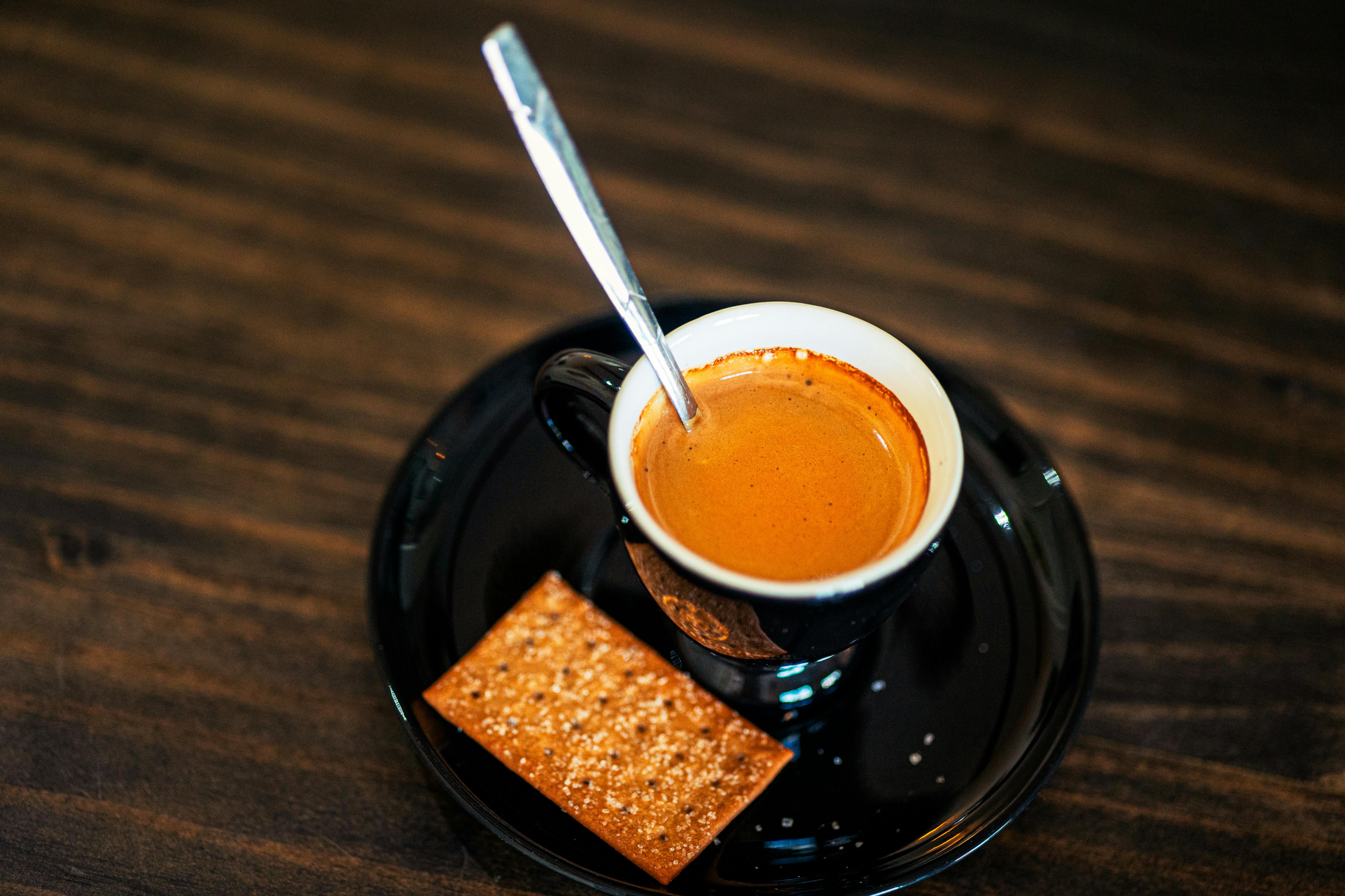 Top View of Espresso with Biscuit on Saucer · Free Stock Photo