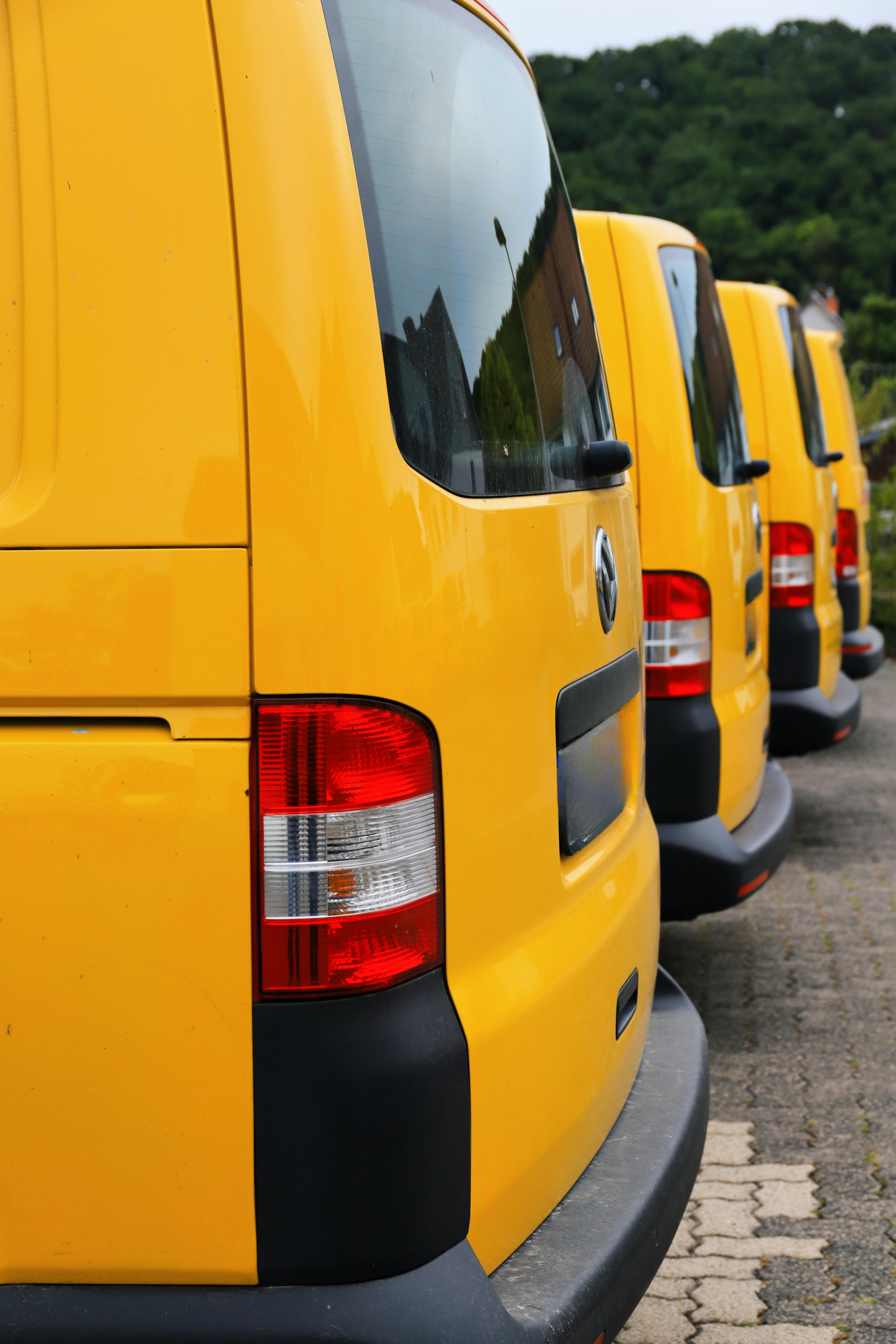 Row of Bright Yellow Vans Parked Outdoors · Free Stock Photo