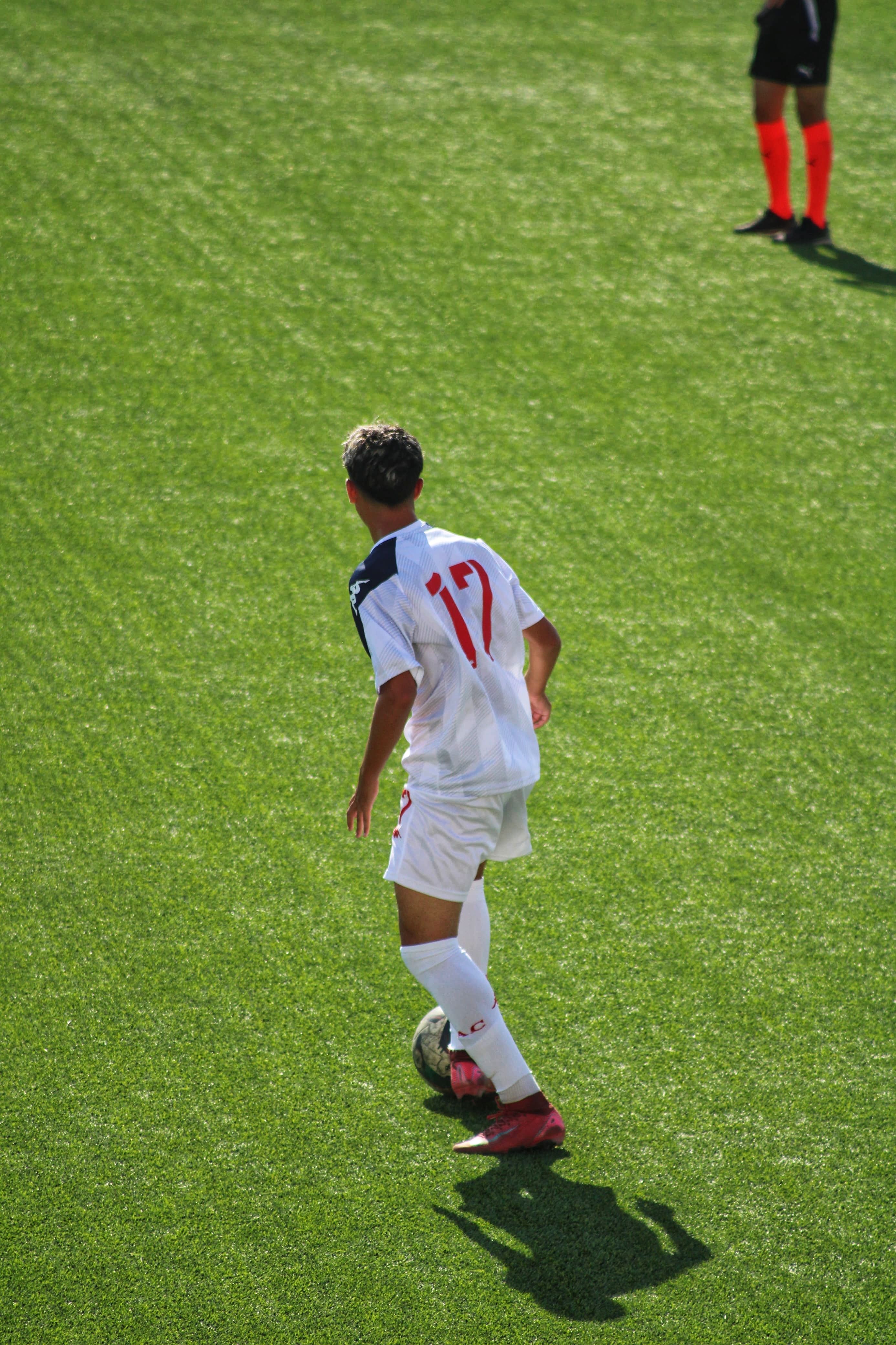 Youth Soccer Player in Action on Field · Free Stock Photo