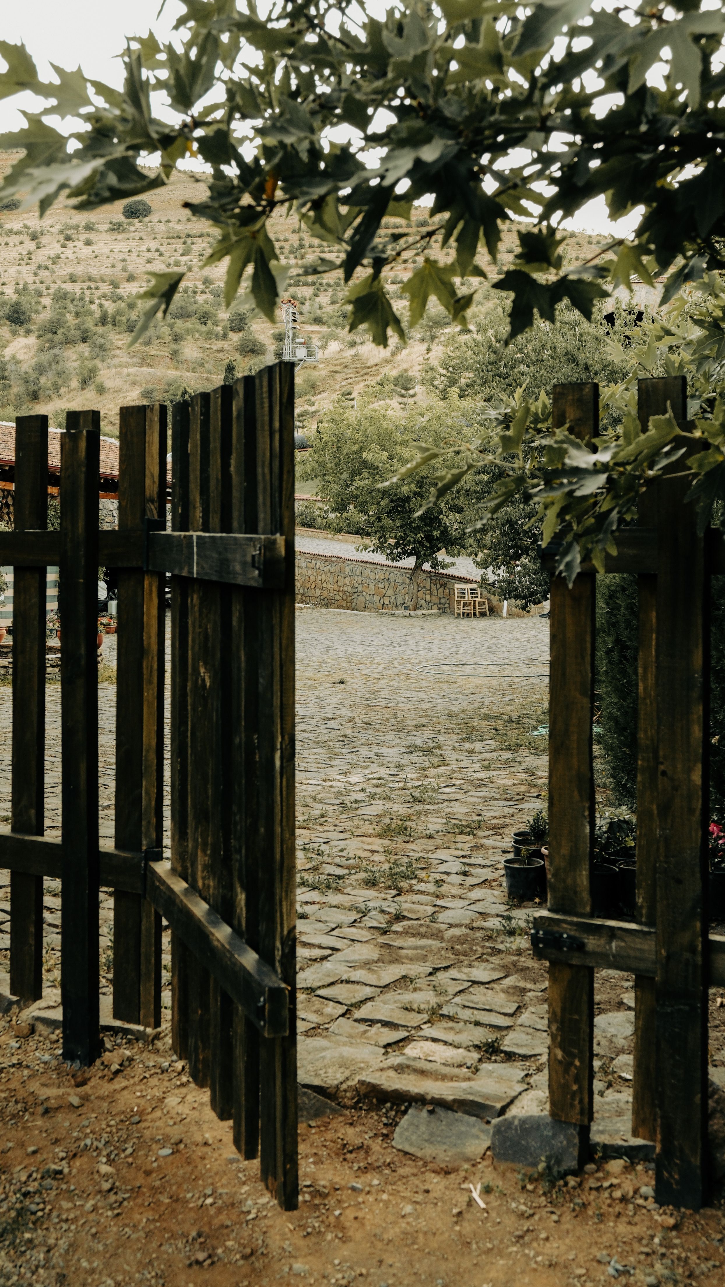 Rustic Wooden Gate Opening to Stone Courtyard · Free Stock Photo