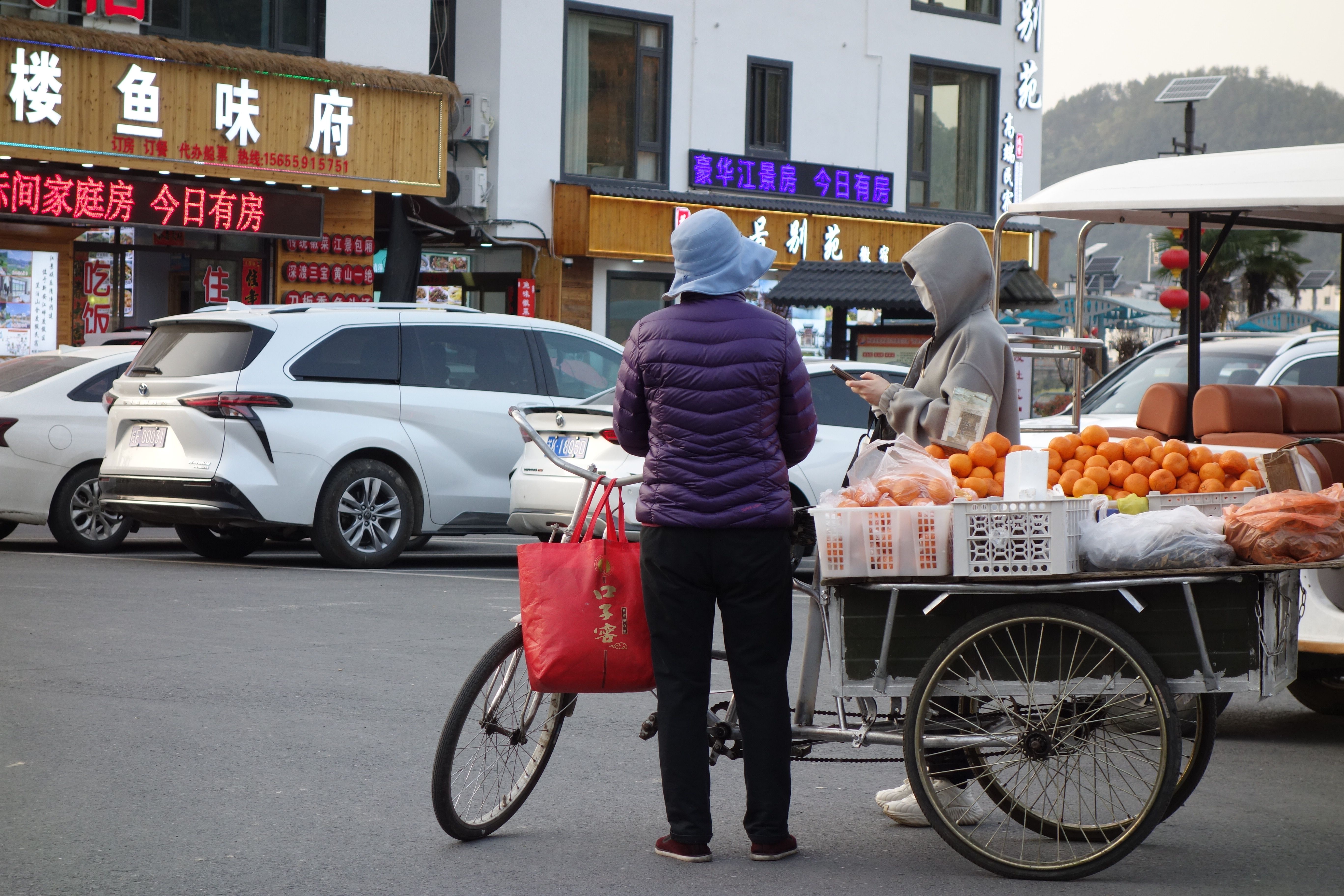 Street Vendor Selling Fresh Oranges in Urban Setting · Free Stock Photo