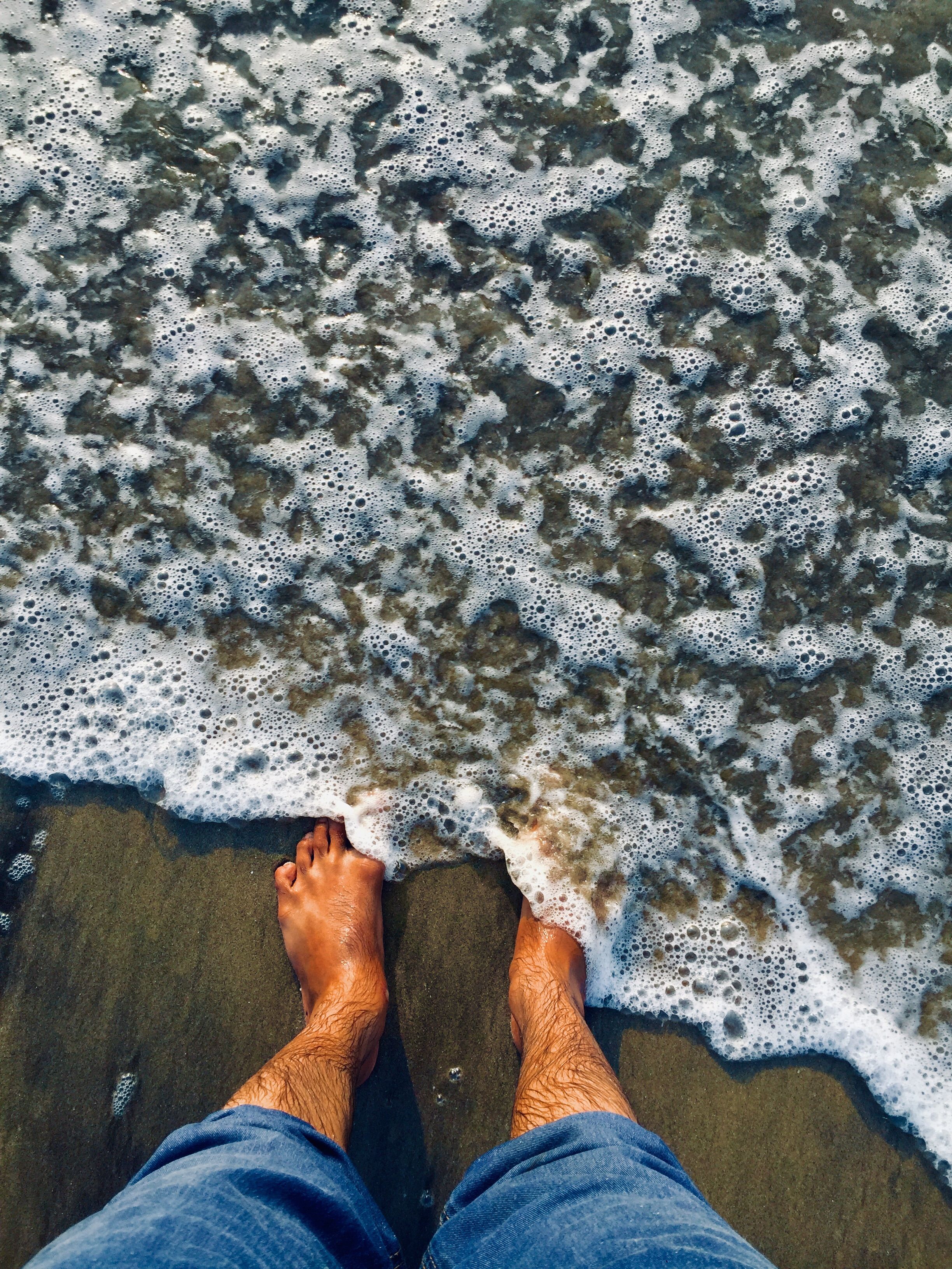 Feet in Ocean Waves at Sunny Beach Shore · Free Stock Photo