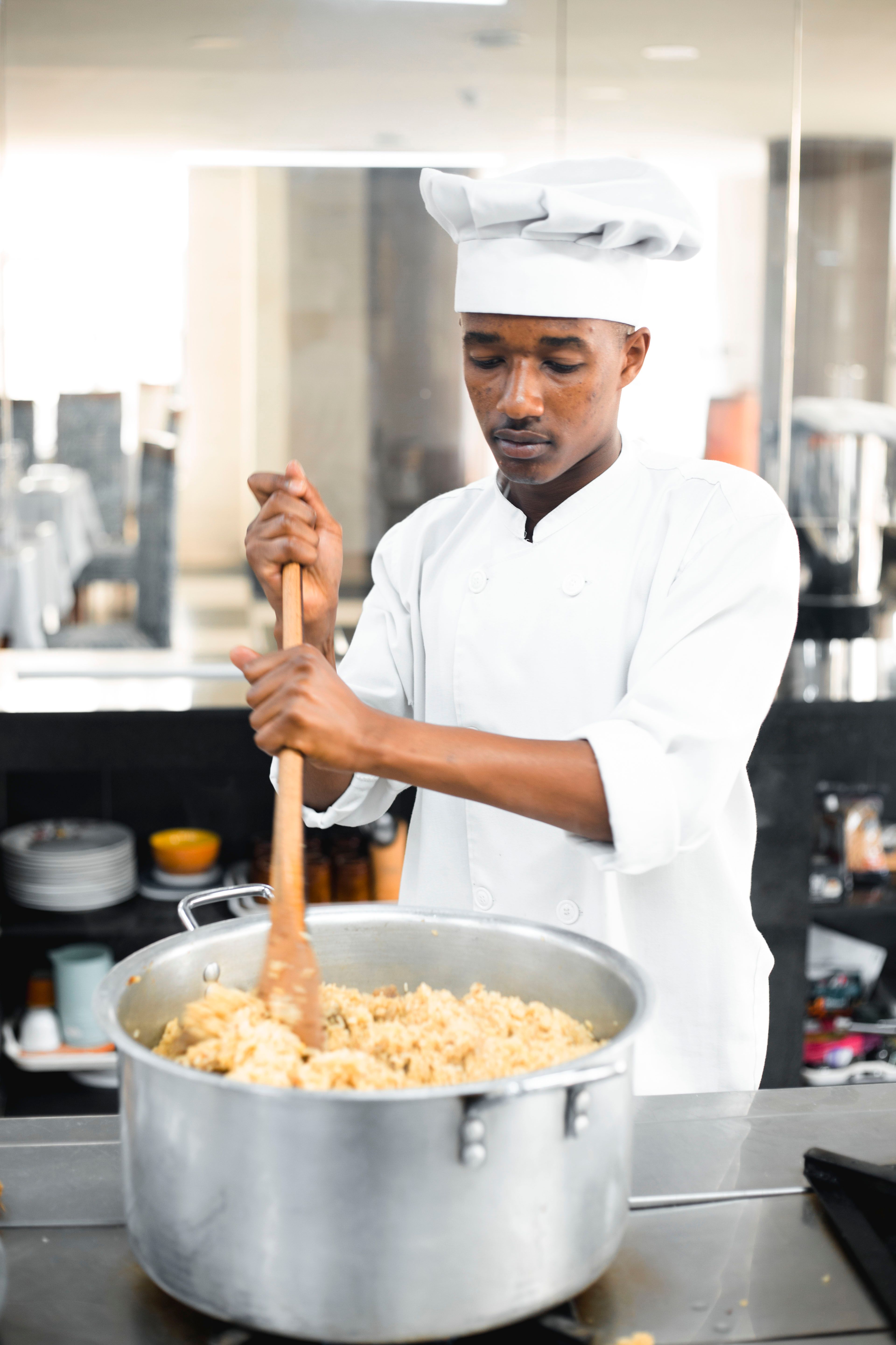 Professional Chef Stirring Large Pot in Modern Kitchen · Free Stock Photo