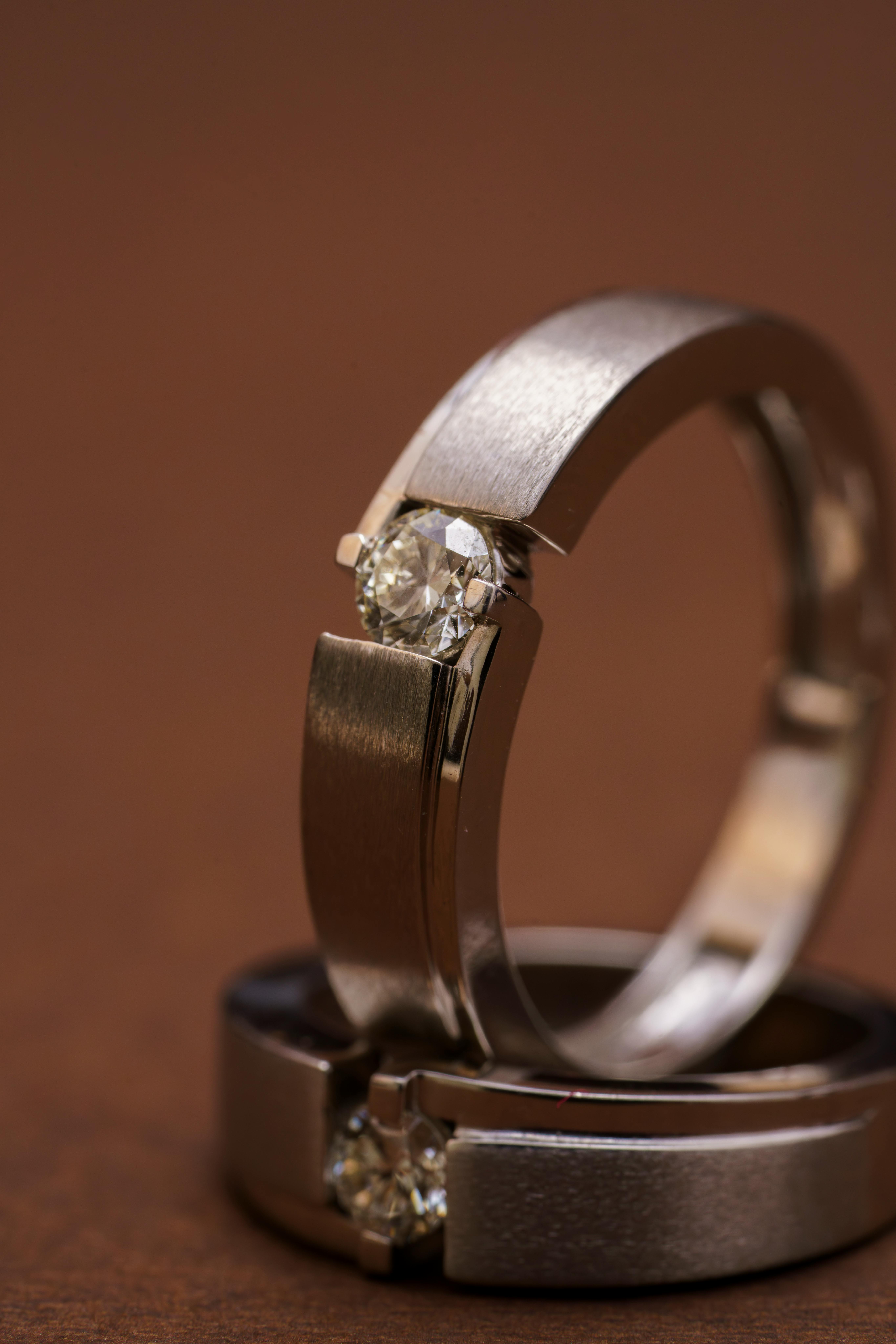 Elegant Diamond Rings on Wooden Surface · Free Stock Photo