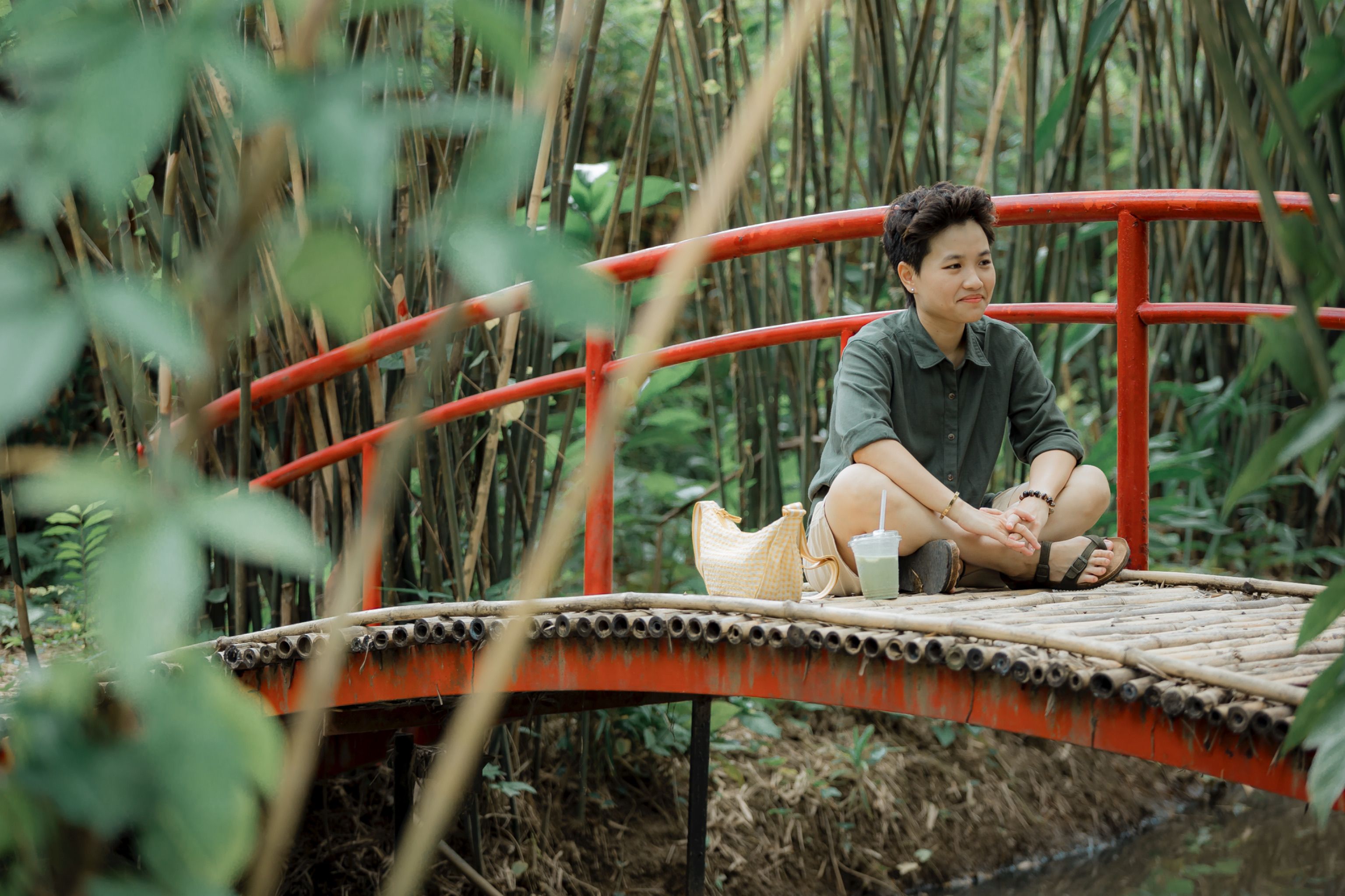 Person Relaxing on Bamboo Bridge in Lush Garden · Free Stock Photo