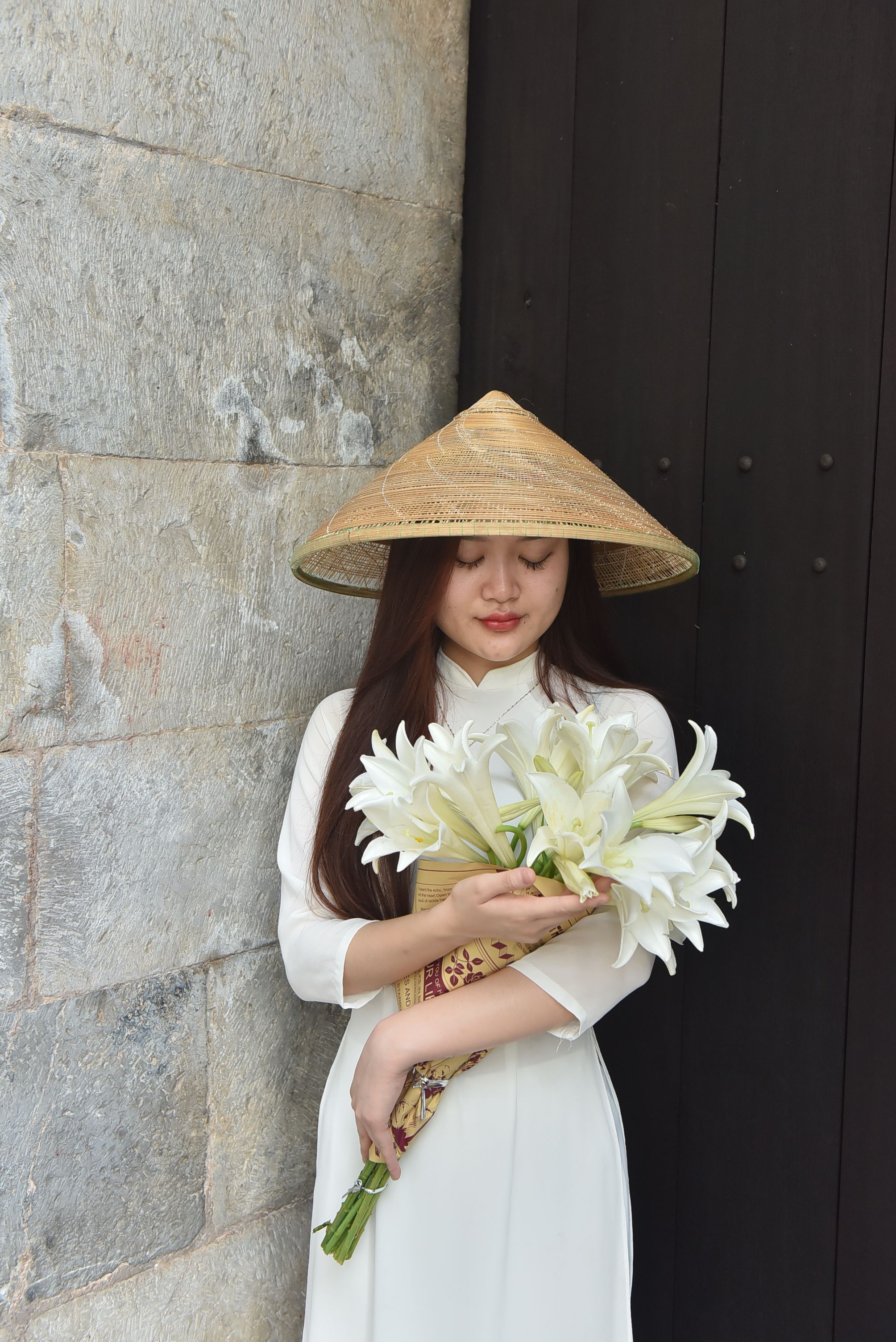 Woman in Traditional Dress Holding Lilies · Free Stock Photo