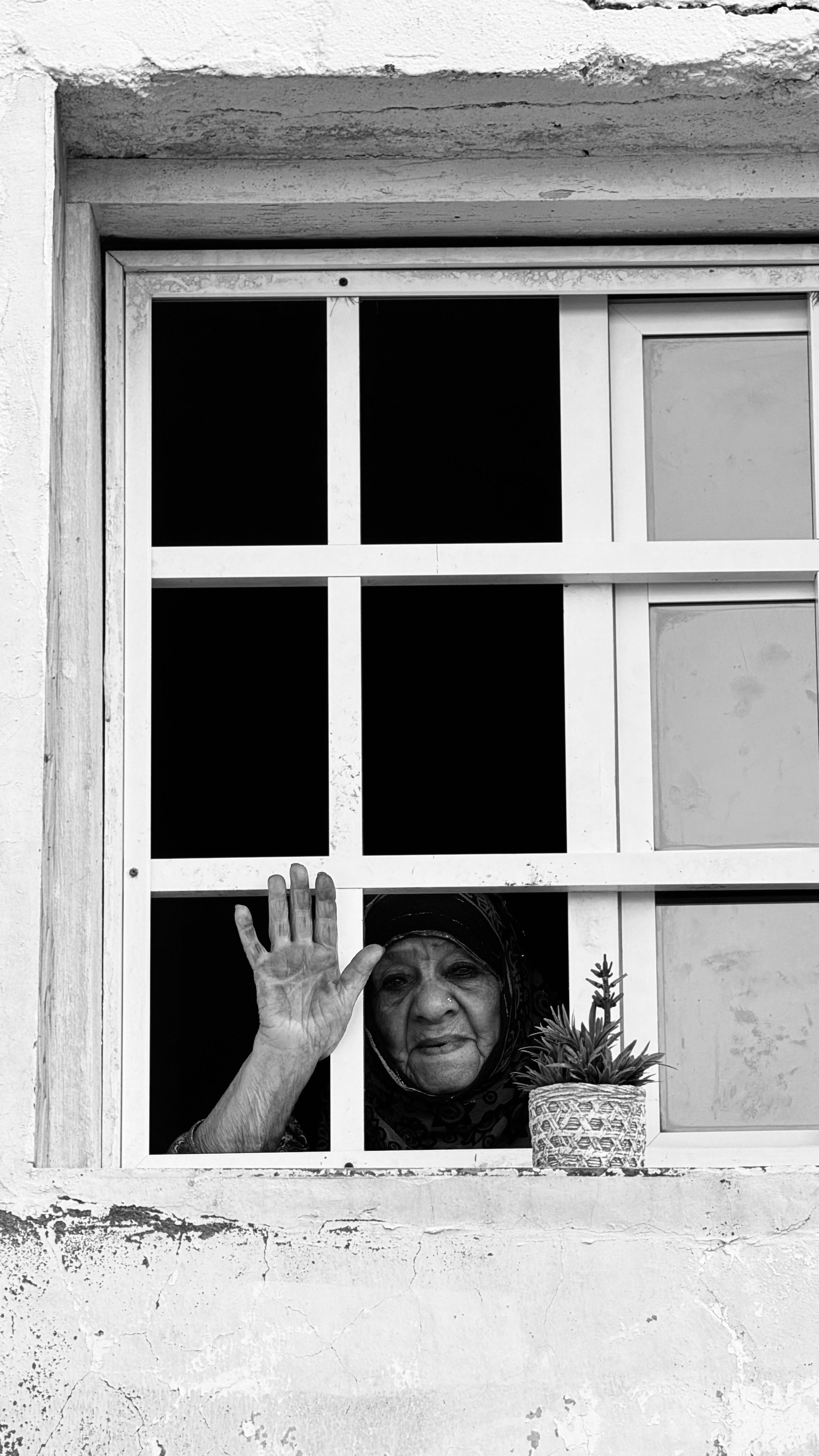 Elderly Woman Waving Through Window in Oman · Free Stock Photo