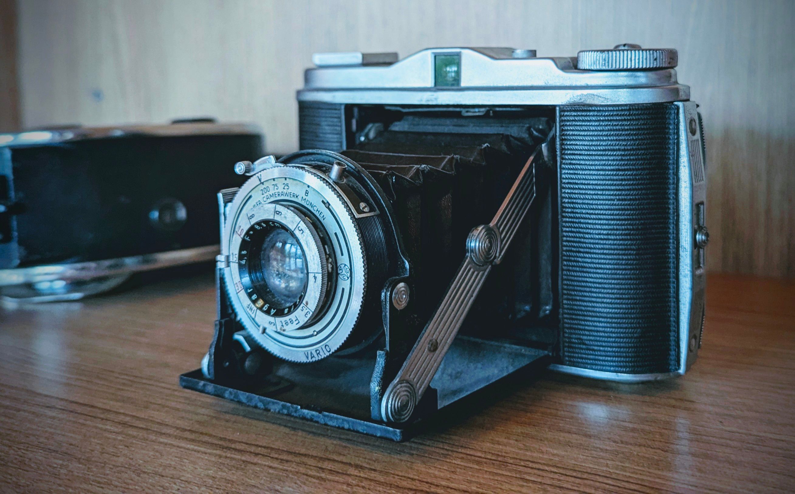 Vintage Foldable Camera on Wooden Shelf · Free Stock Photo