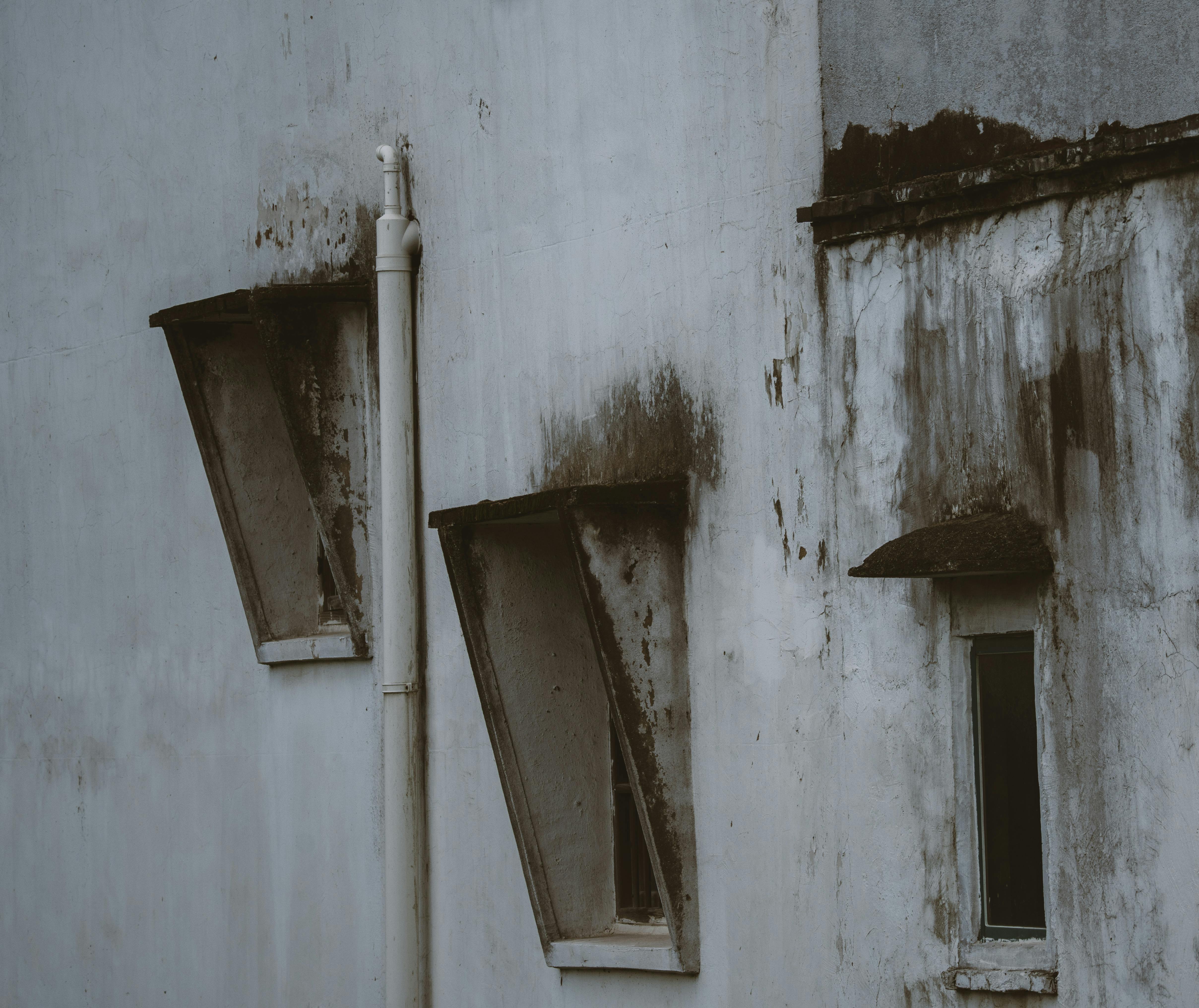 Weathered Building Facade with Rustic Windows · Free Stock Photo