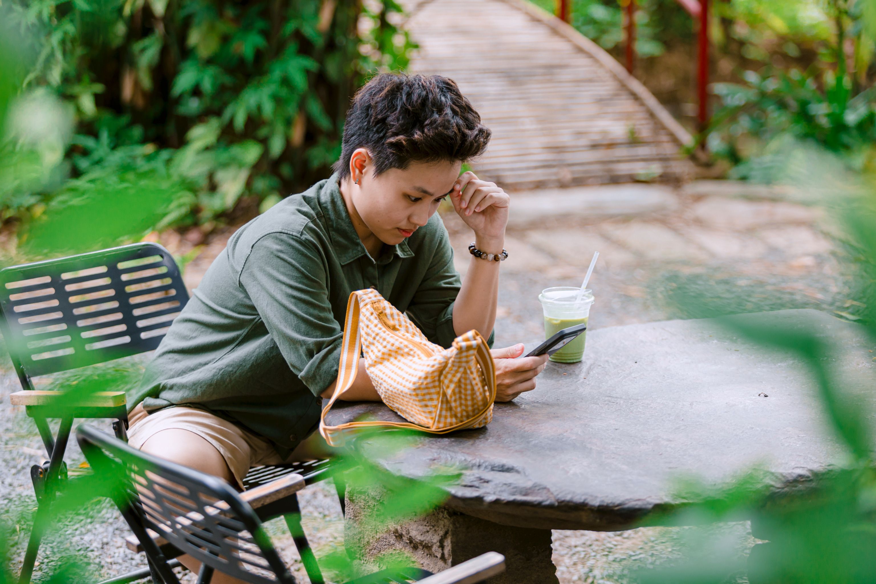 Young Adult Relaxing Outdoors with Smartphone · Free Stock Photo