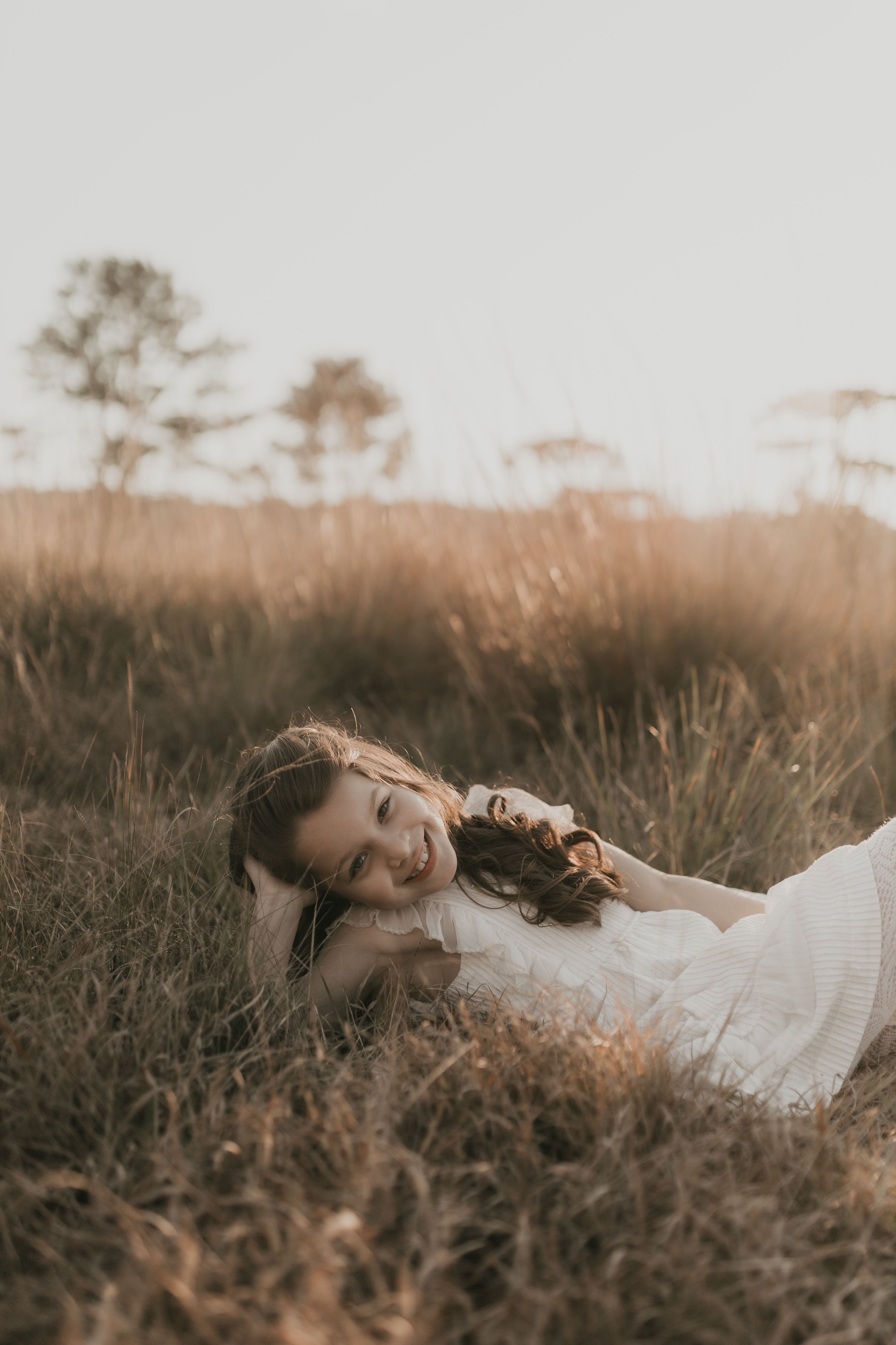 Young Girl Relaxing in Sunlit Field · Free Stock Photo