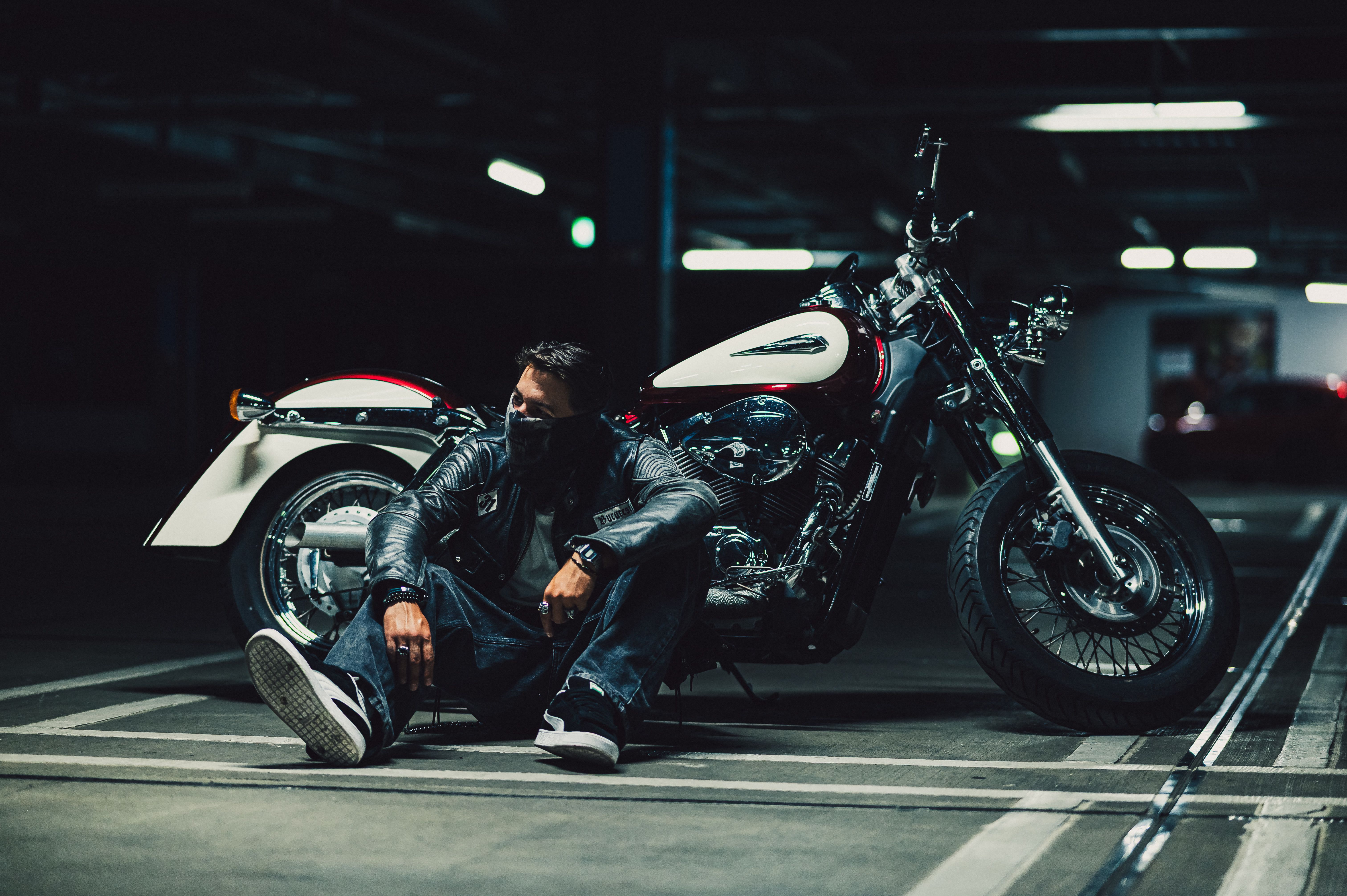 Motorcyclist Sitting by Chopper in Urban Garage · Free Stock Photo