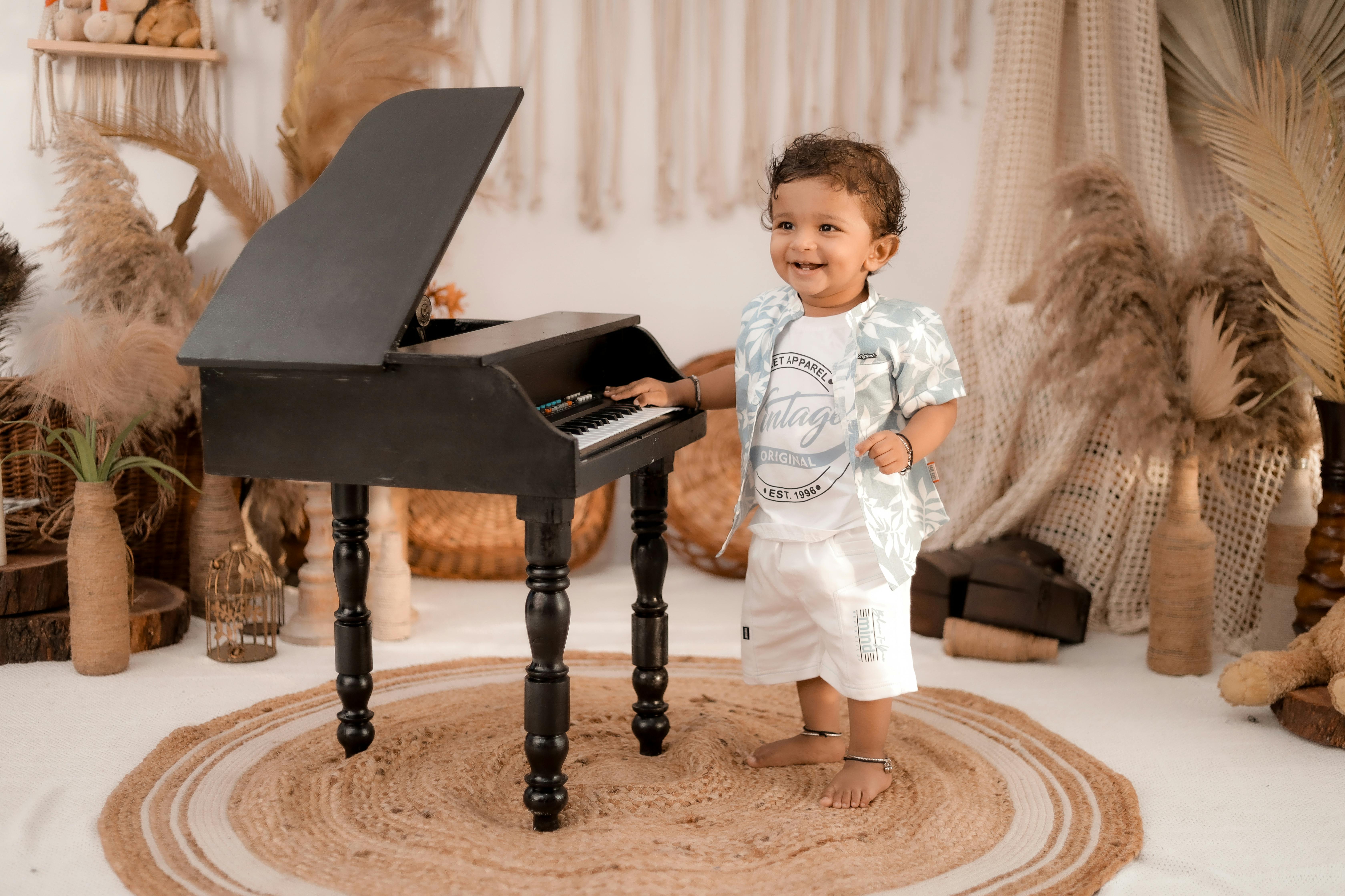 Adorable Child Playing Toy Piano in Boho Room · Free Stock Photo