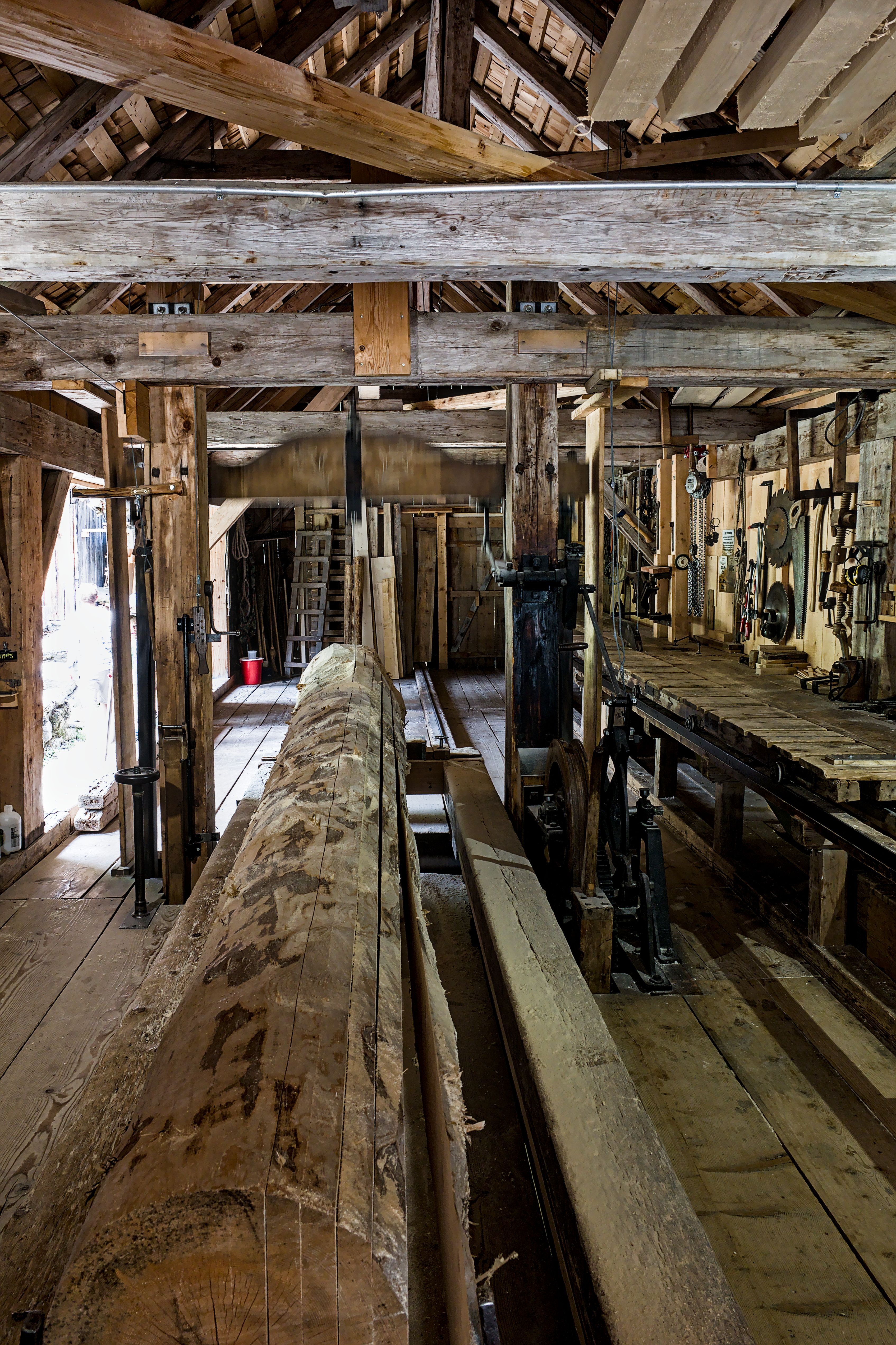 Historic Swiss Sawmill Interior with Wooden Log · Free Stock Photo
