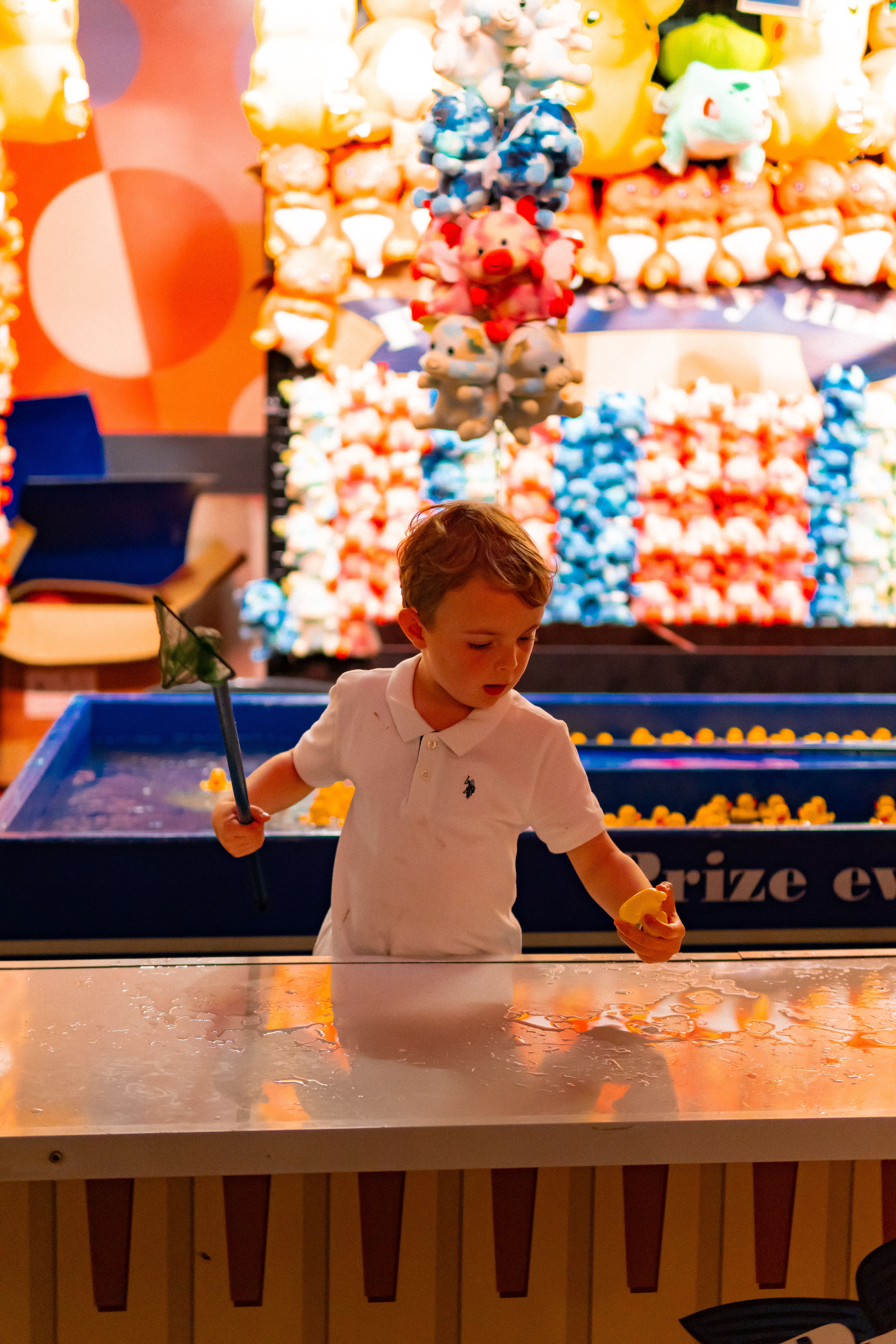 Young Boy Playing a Carnival Game Indoors · Free Stock Photo