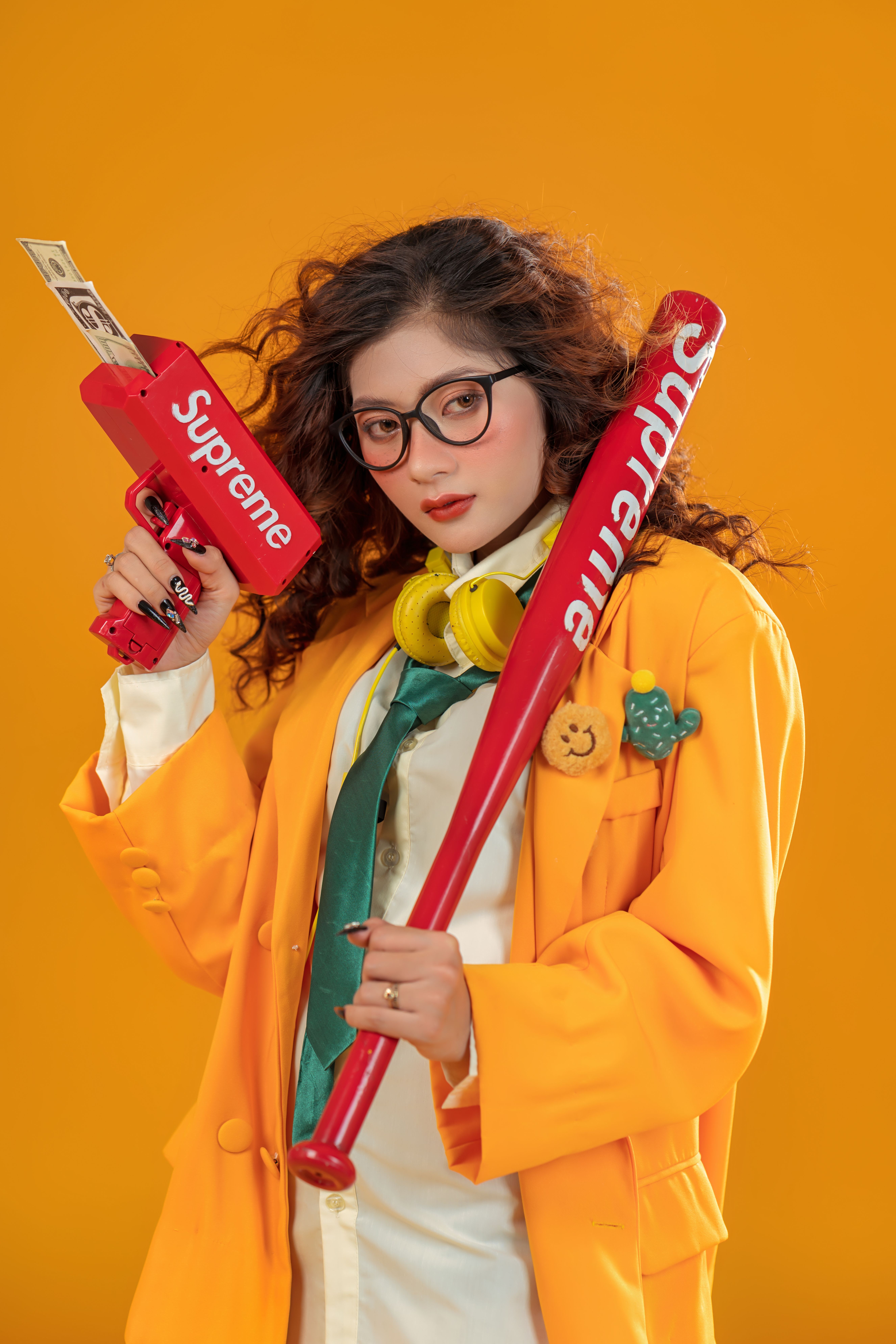Stylish Woman Holding Toy Gun and Bat on Orange Background · Free Stock ...