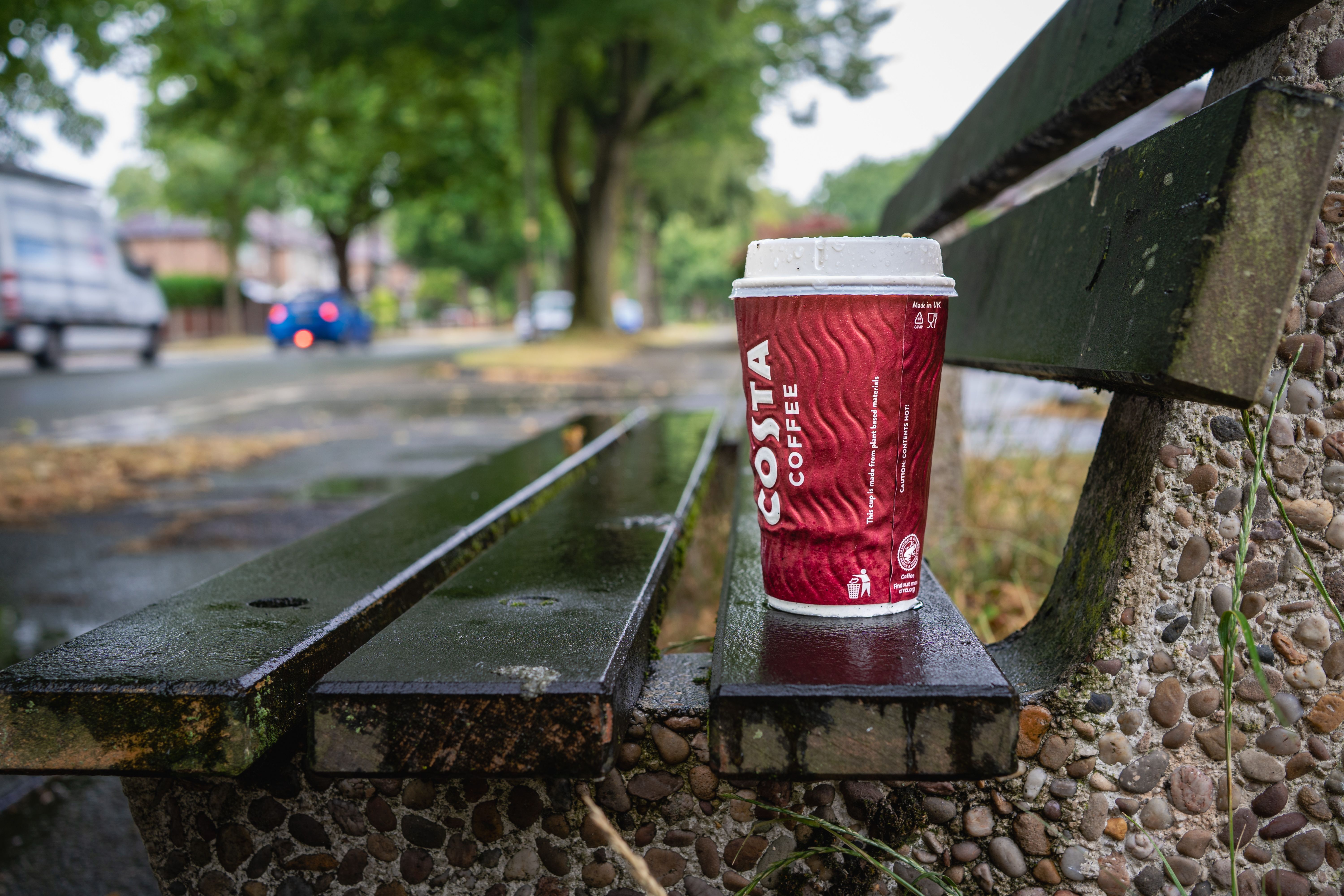 Wet Bench with Coffee Cup on a Rainy Street · Free Stock Photo