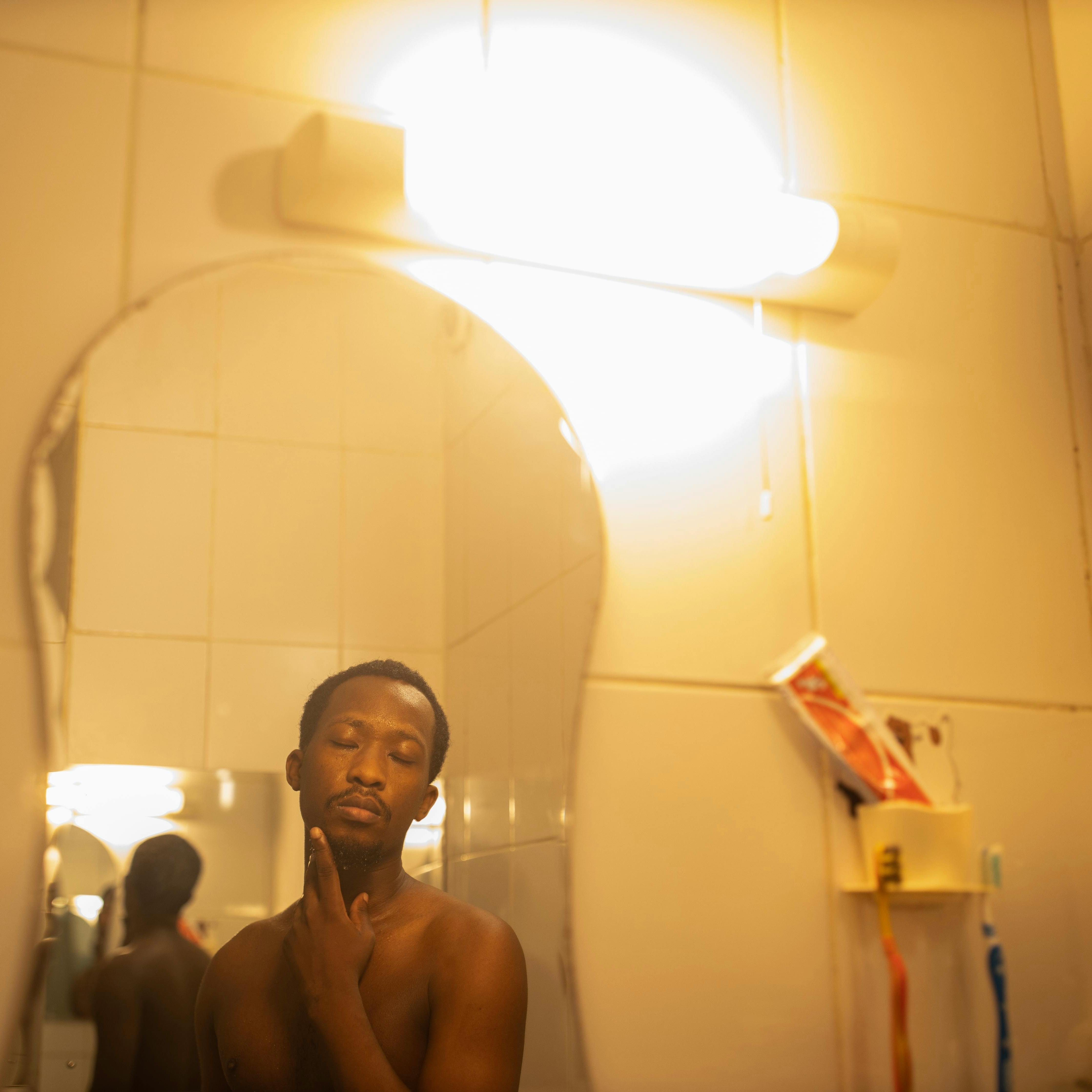 Contemplative Moment in Bathroom Mirror · Free Stock Photo