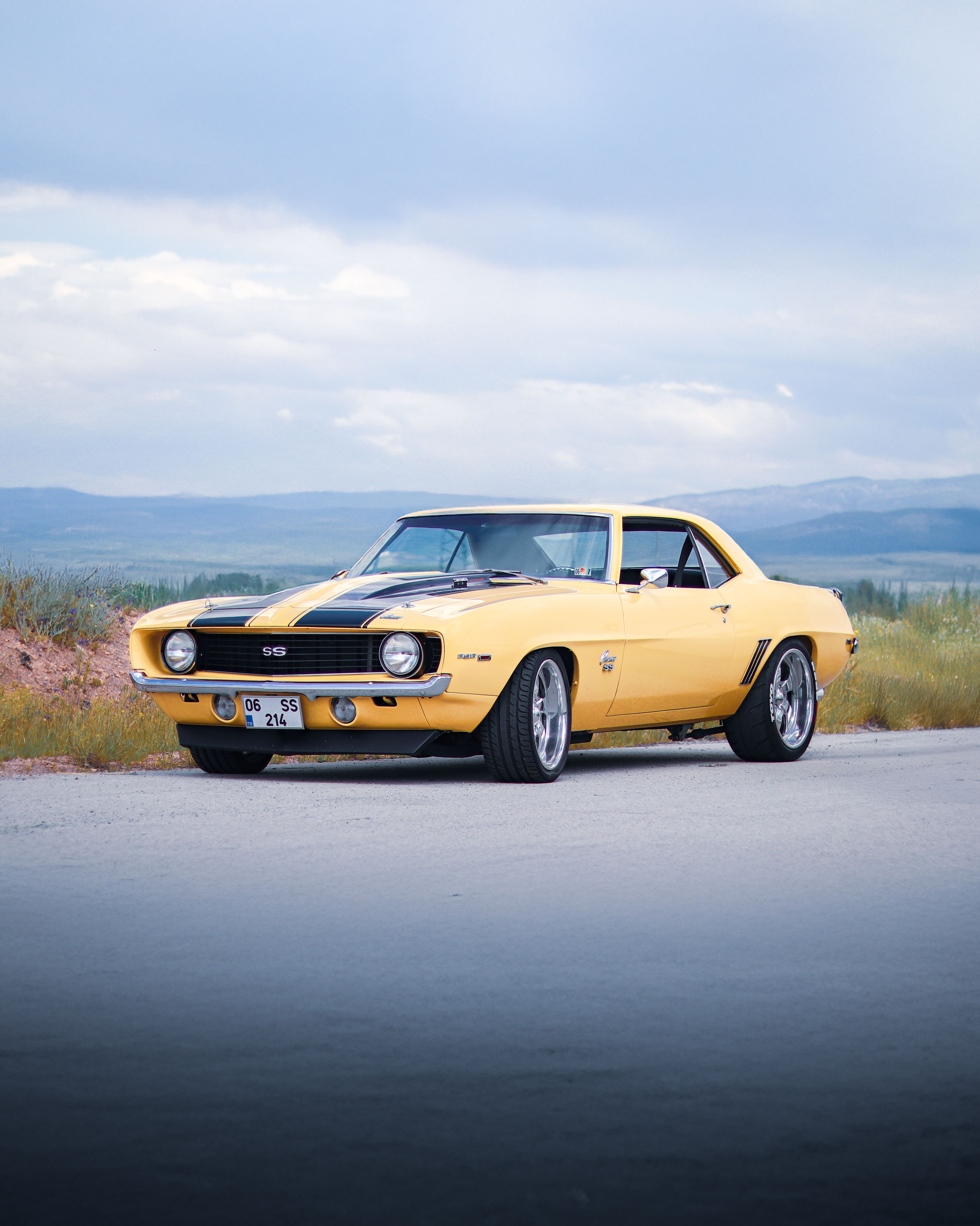 Classic Yellow Muscle Car on Scenic Highway · Free Stock Photo
