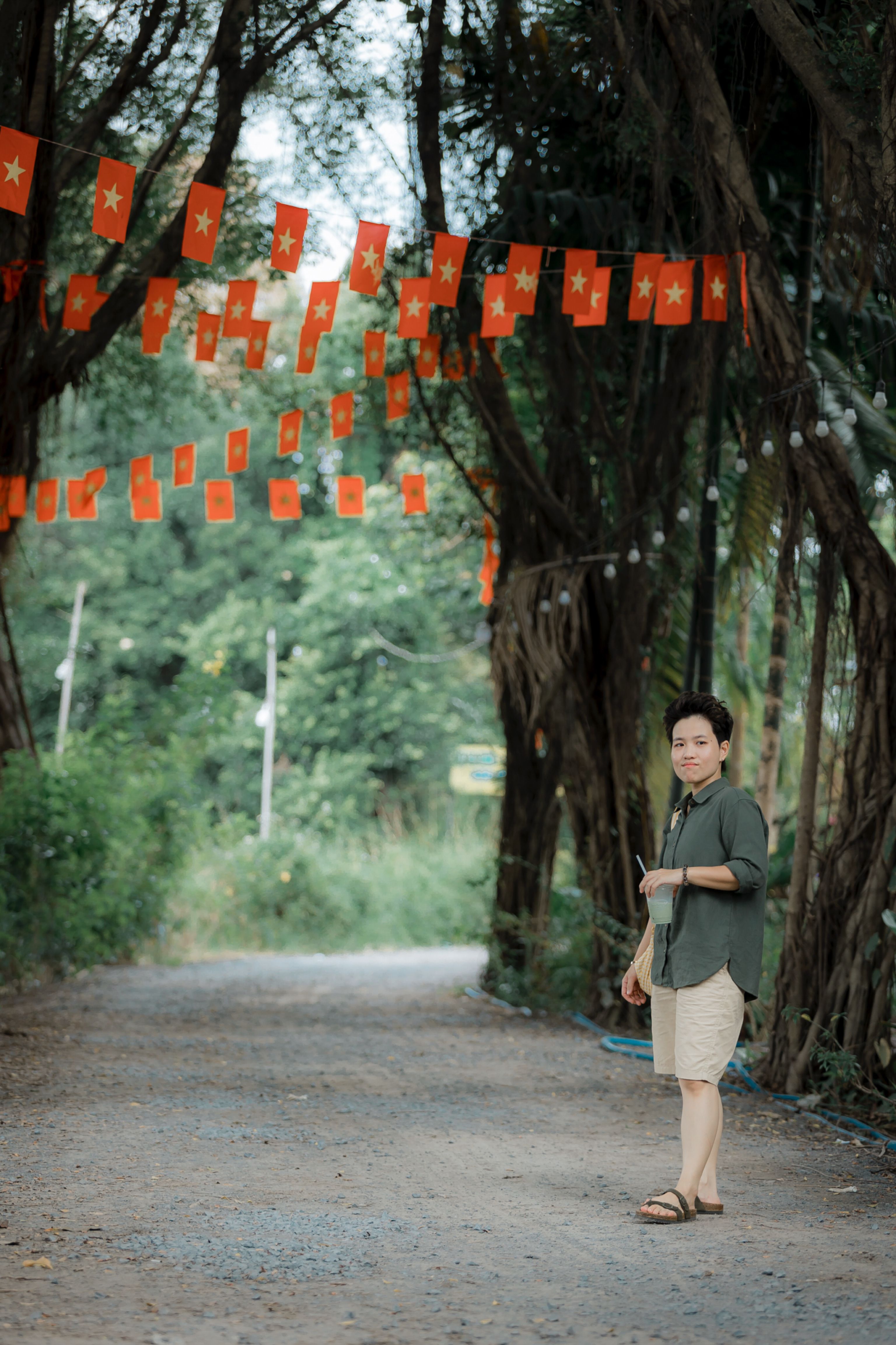 Person Walking Under Red Flags in Forest Pathway · Free Stock Photo