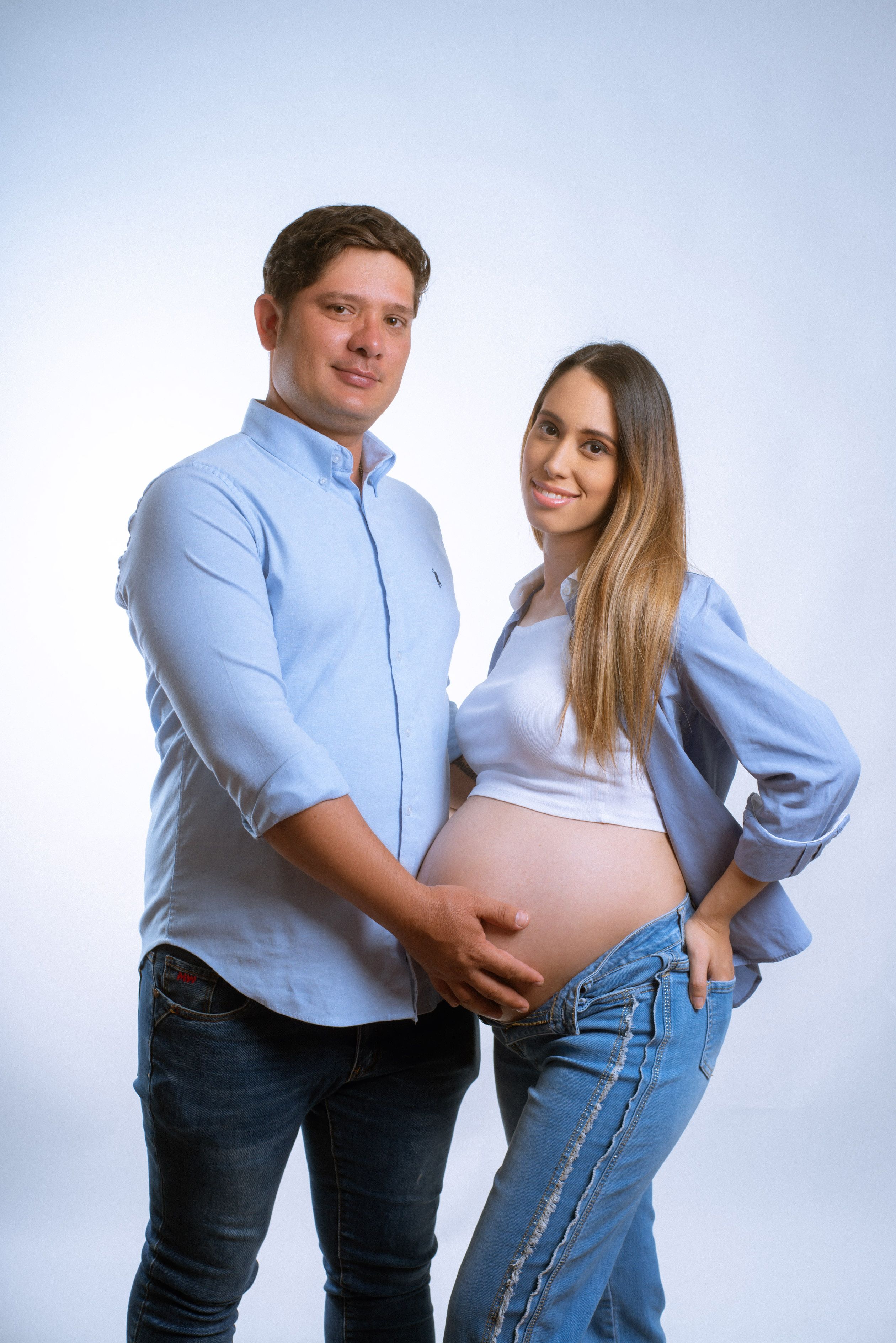 Happy Expecting Couple Posing in Studio · Free Stock Photo