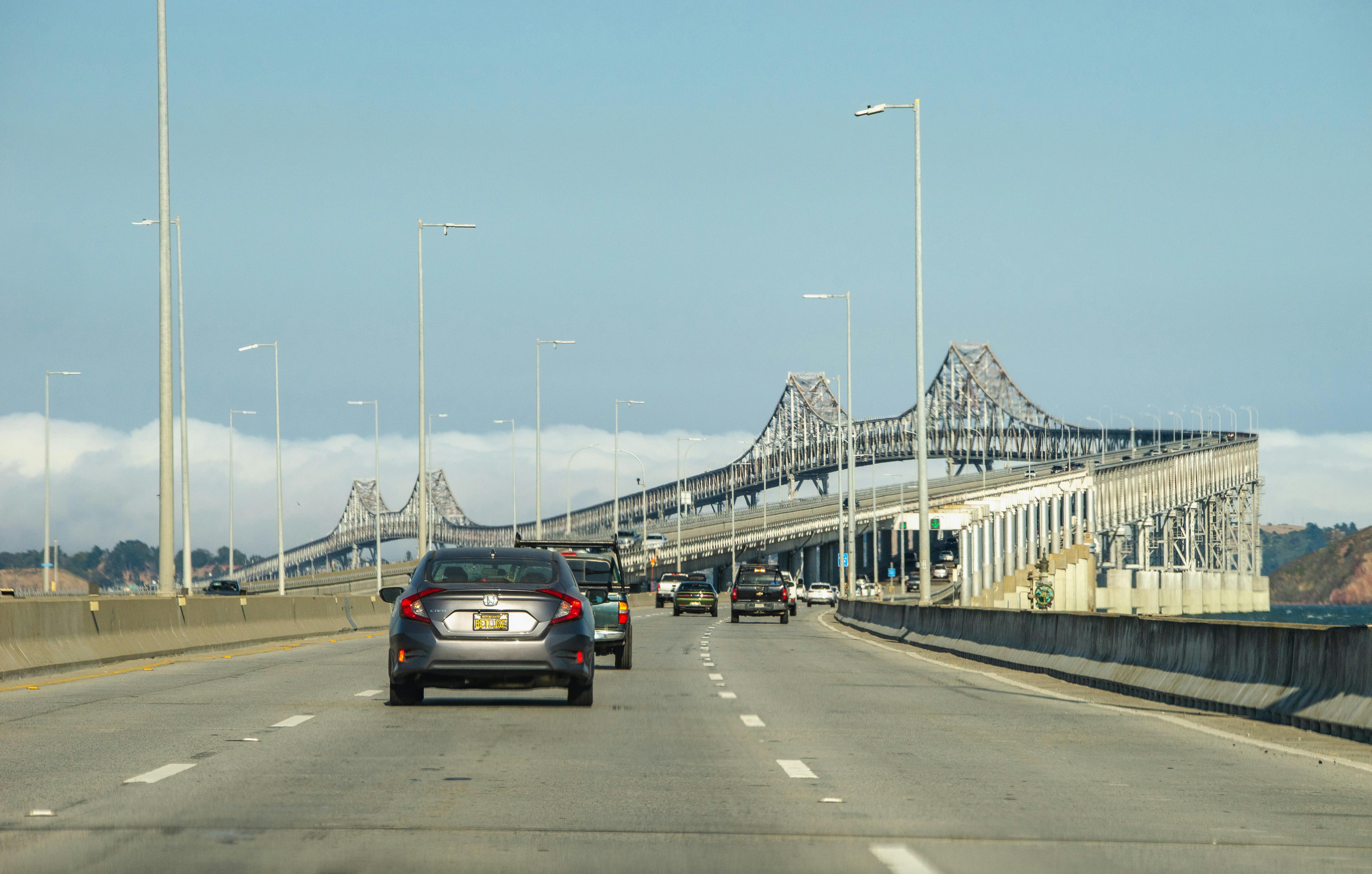Cars Cross Bay Bridge Under Clear Blue Sky · Free Stock Photo