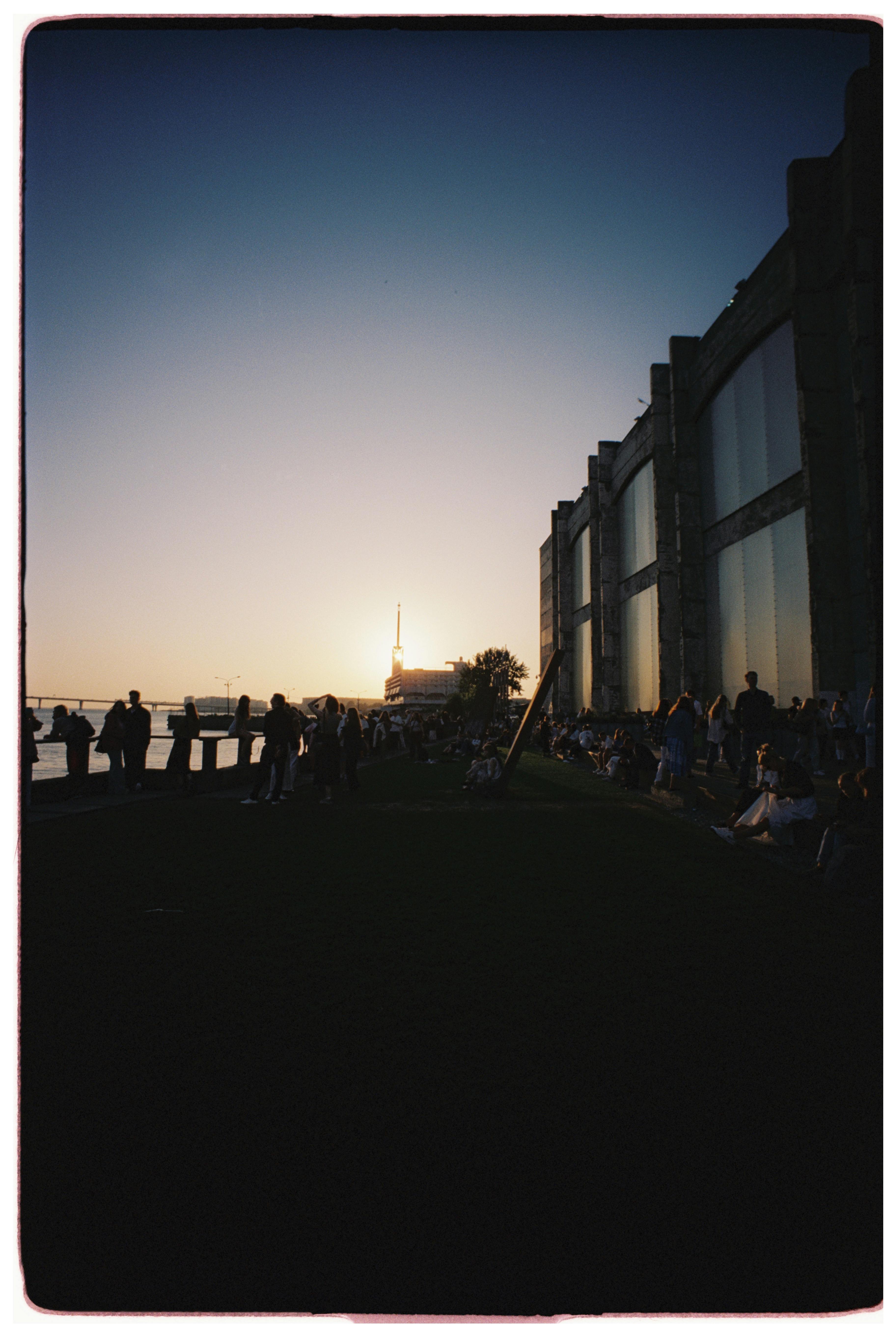 Sunset Gathering at Waterfront with Silhouettes · Free Stock Photo