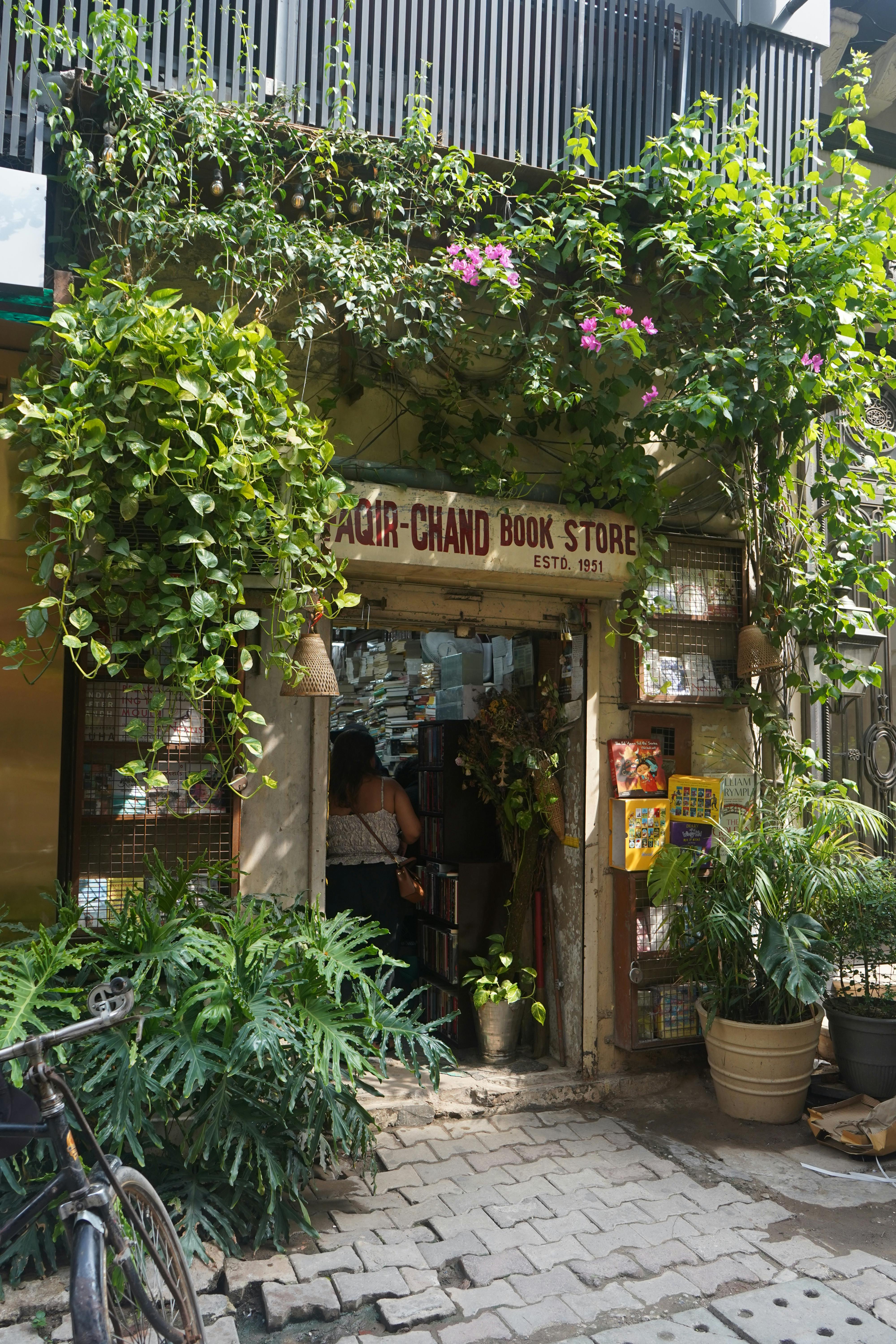Charming Outdoor Bookstore Entry with Lush Greenery · Free Stock Photo