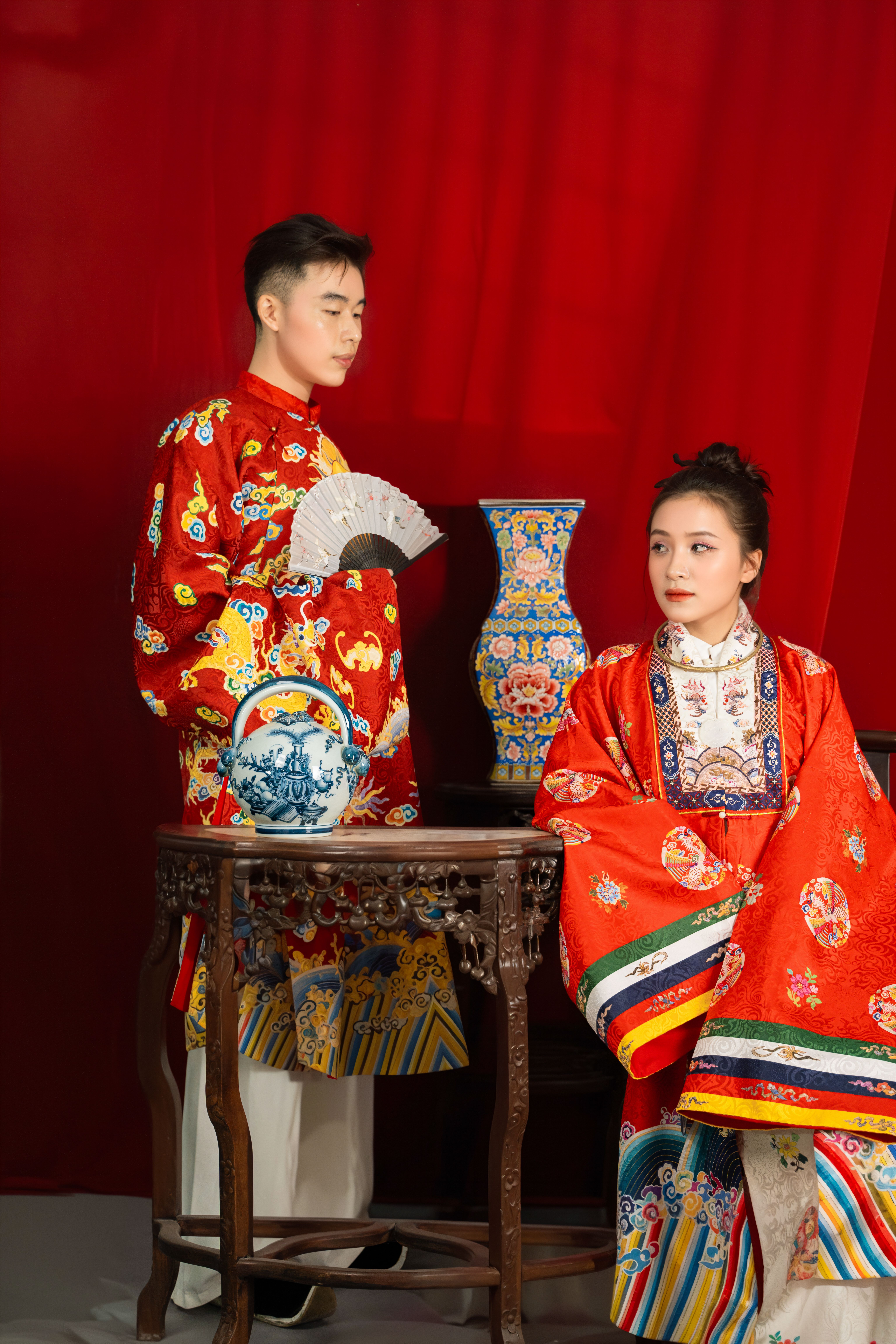 Traditional Chinese Attire with Vibrant Red Background · Free Stock Photo
