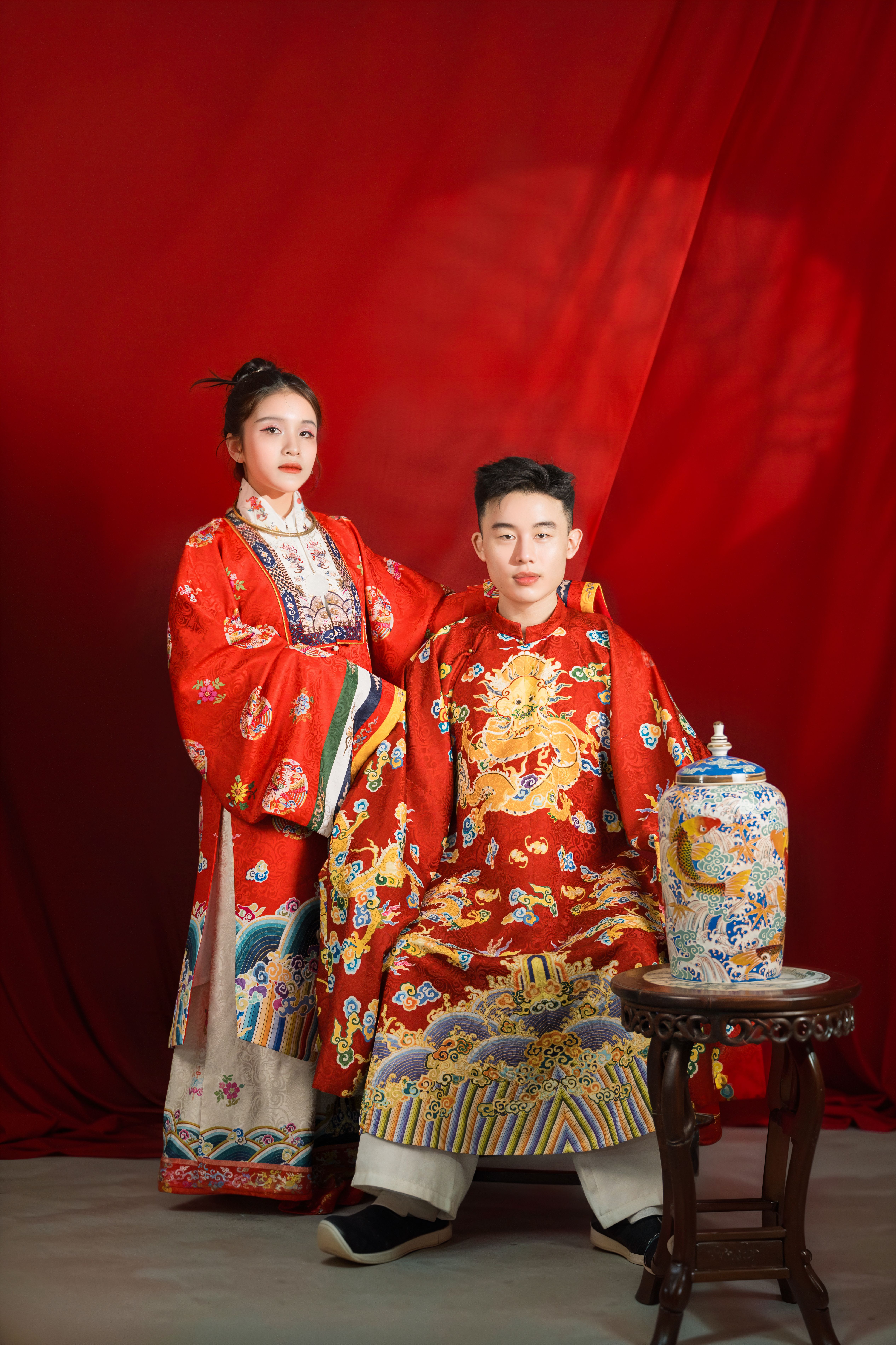 Traditional Chinese Attire Portrait with Red Backdrop · Free Stock Photo