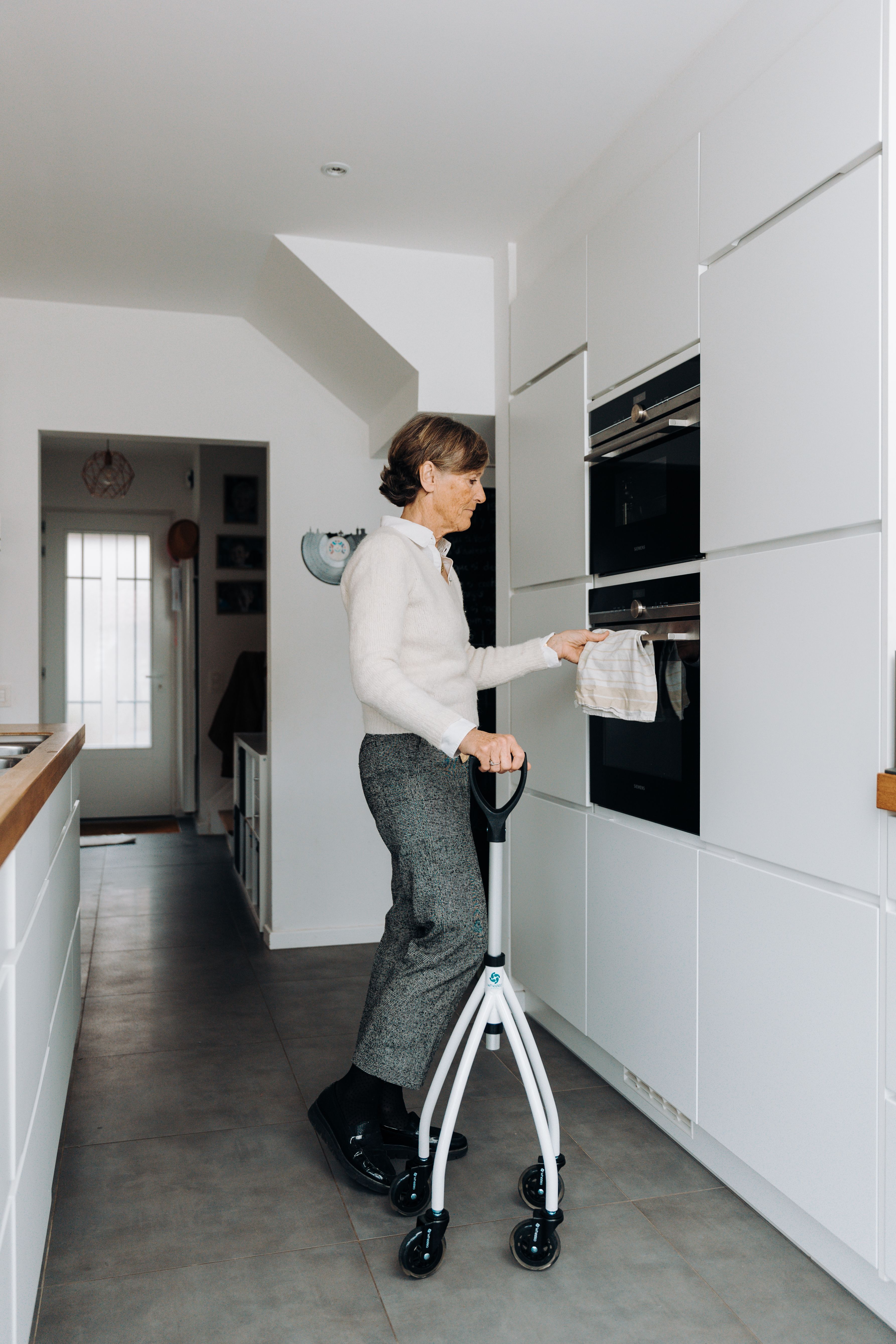 Senior Adult Using Mobility Aid in Modern Kitchen · Free Stock Photo