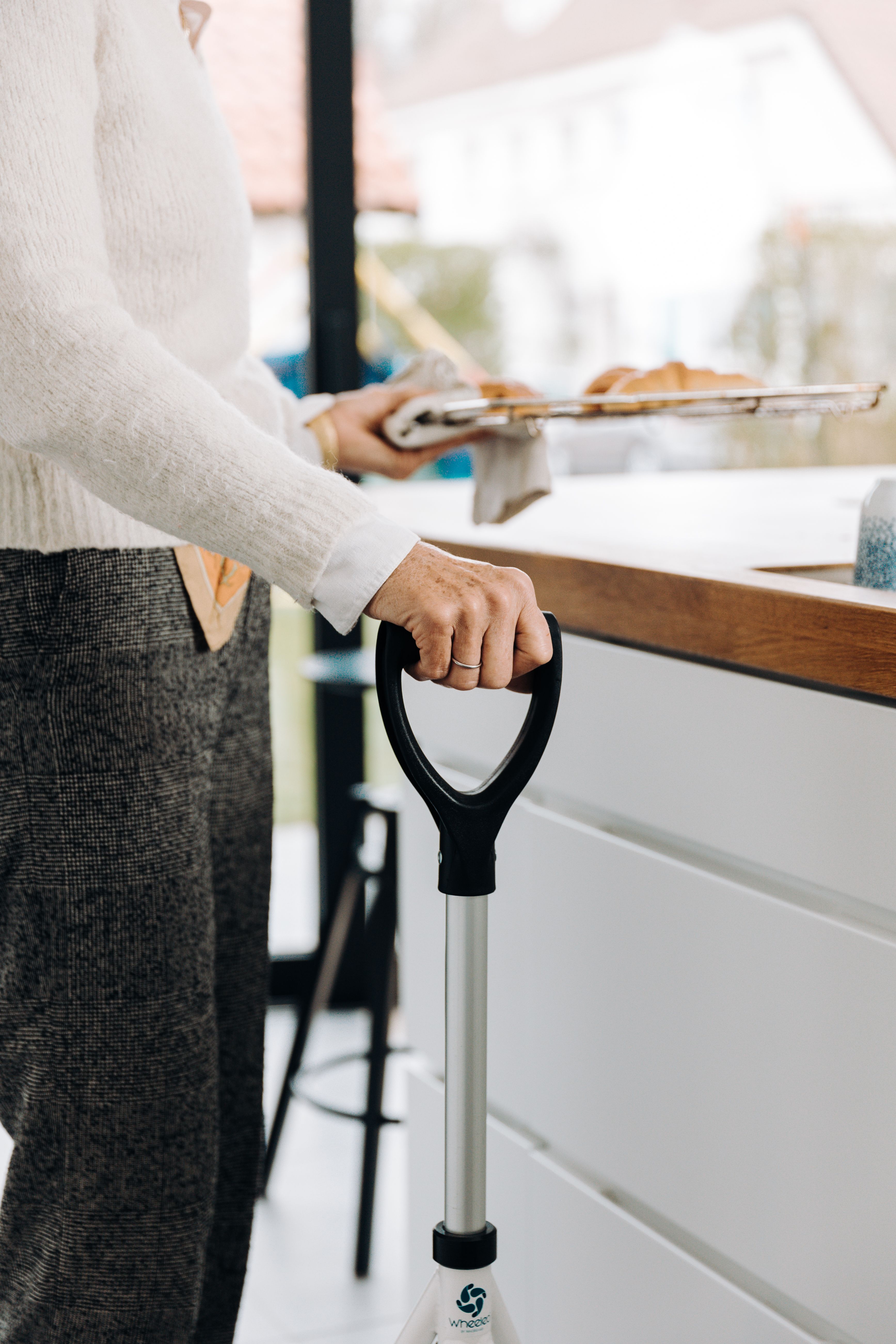 Senior Adult Using Mobility Aid in Modern Kitchen · Free Stock Photo